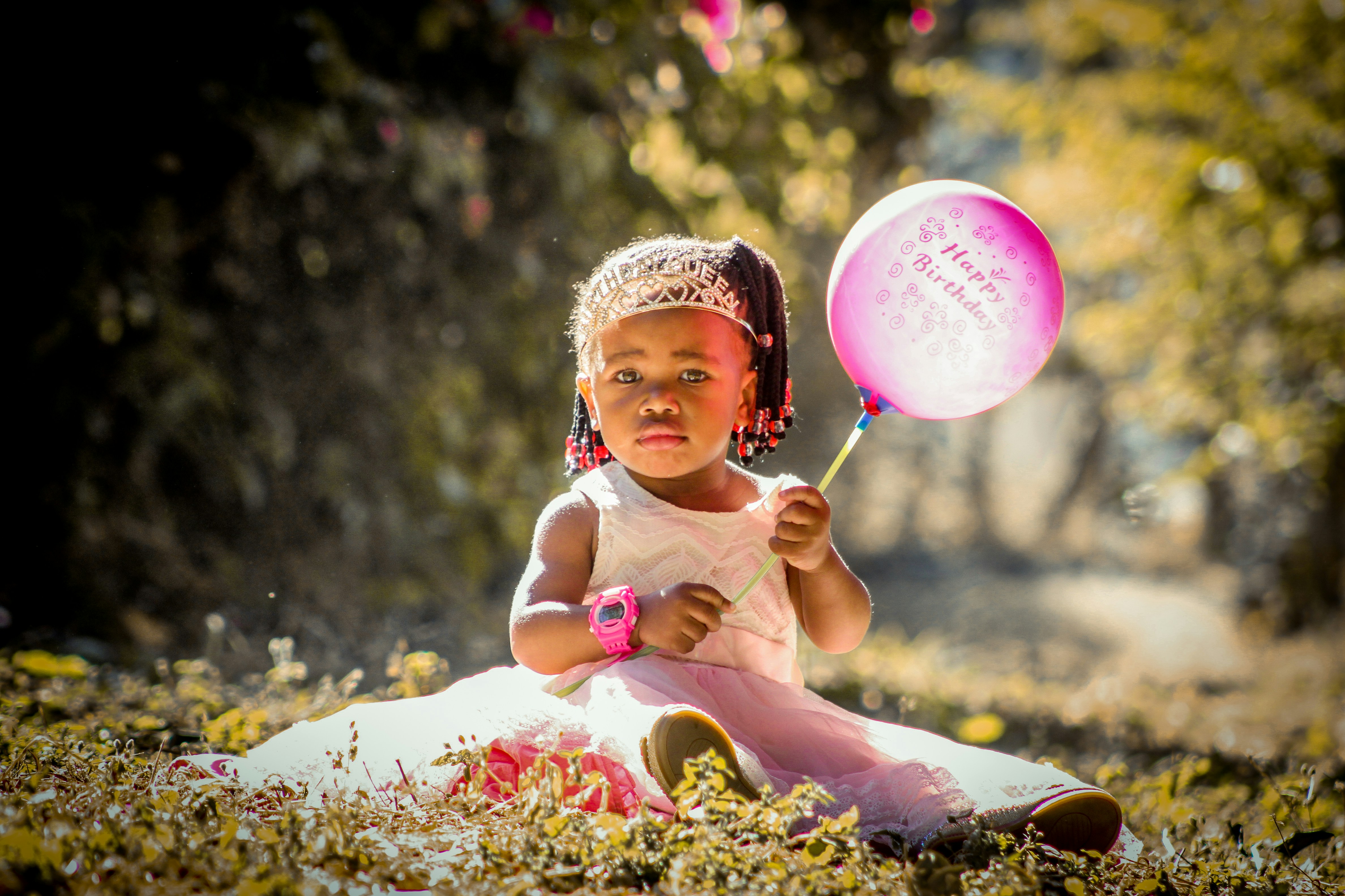 A little girl sitting on the ground holding a pink frisbee photo – Free ...
