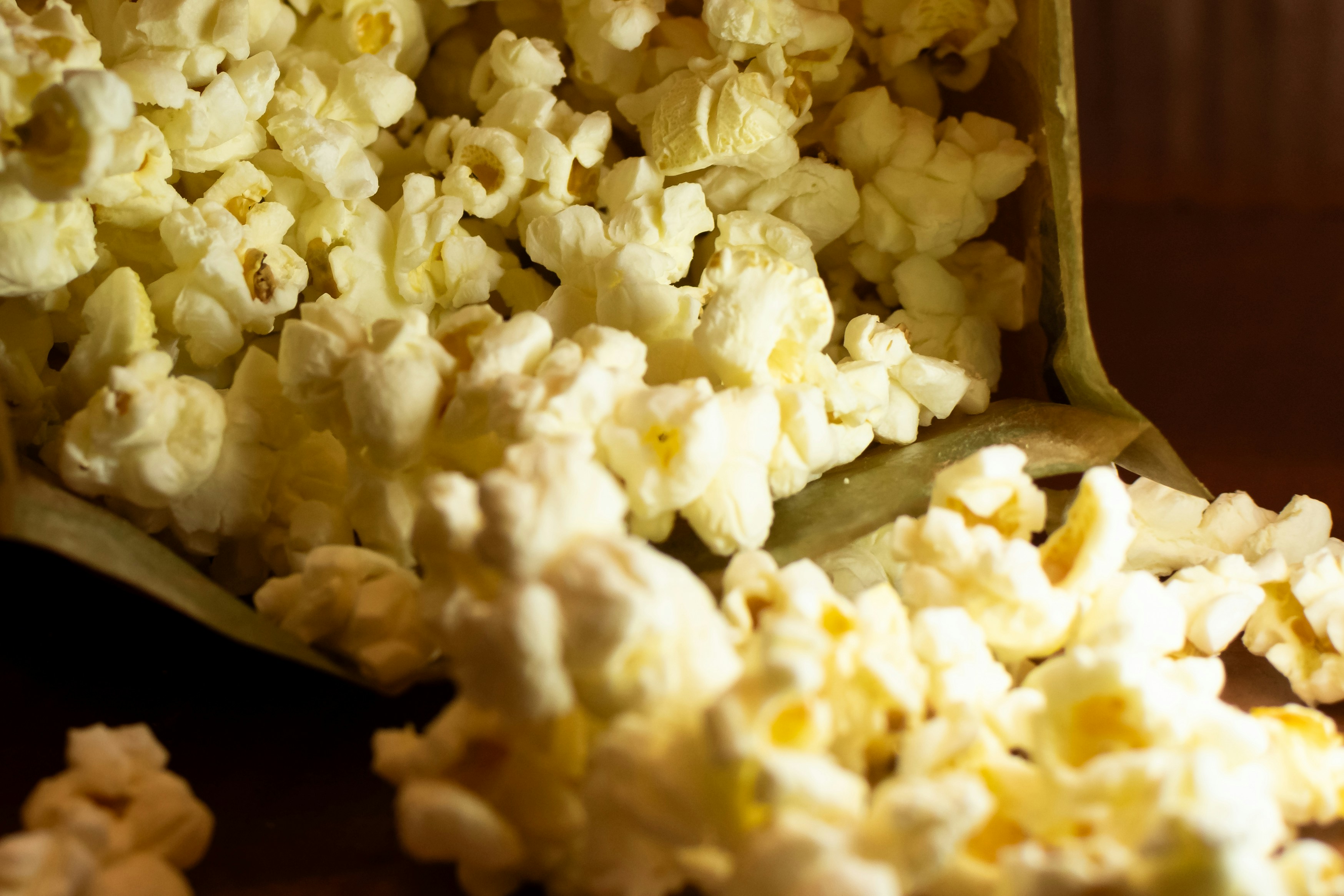 Golden Popcorn Cascade on Rustic Wood Under Cozy Lighting