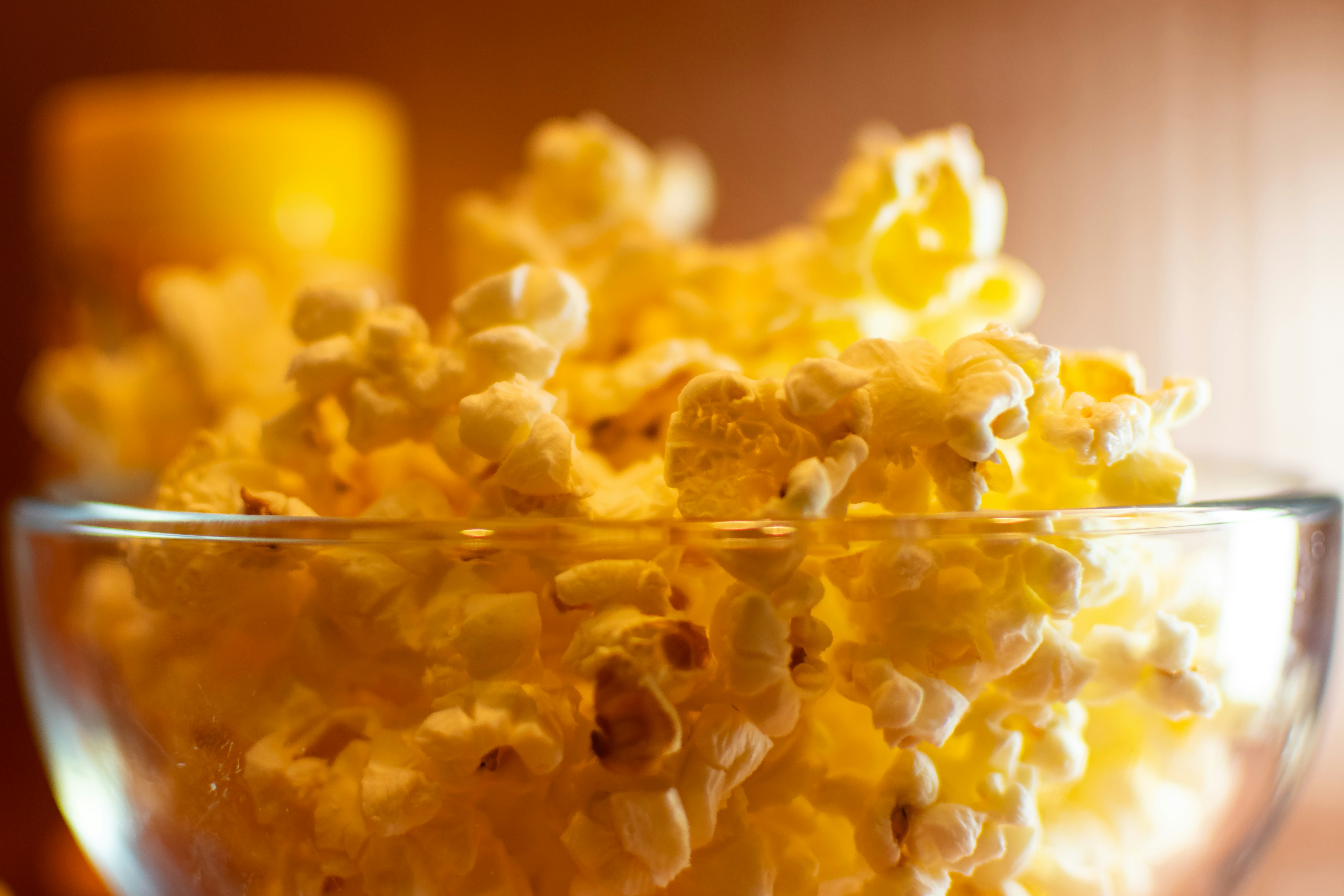 A clear bowl of popped popcorn.