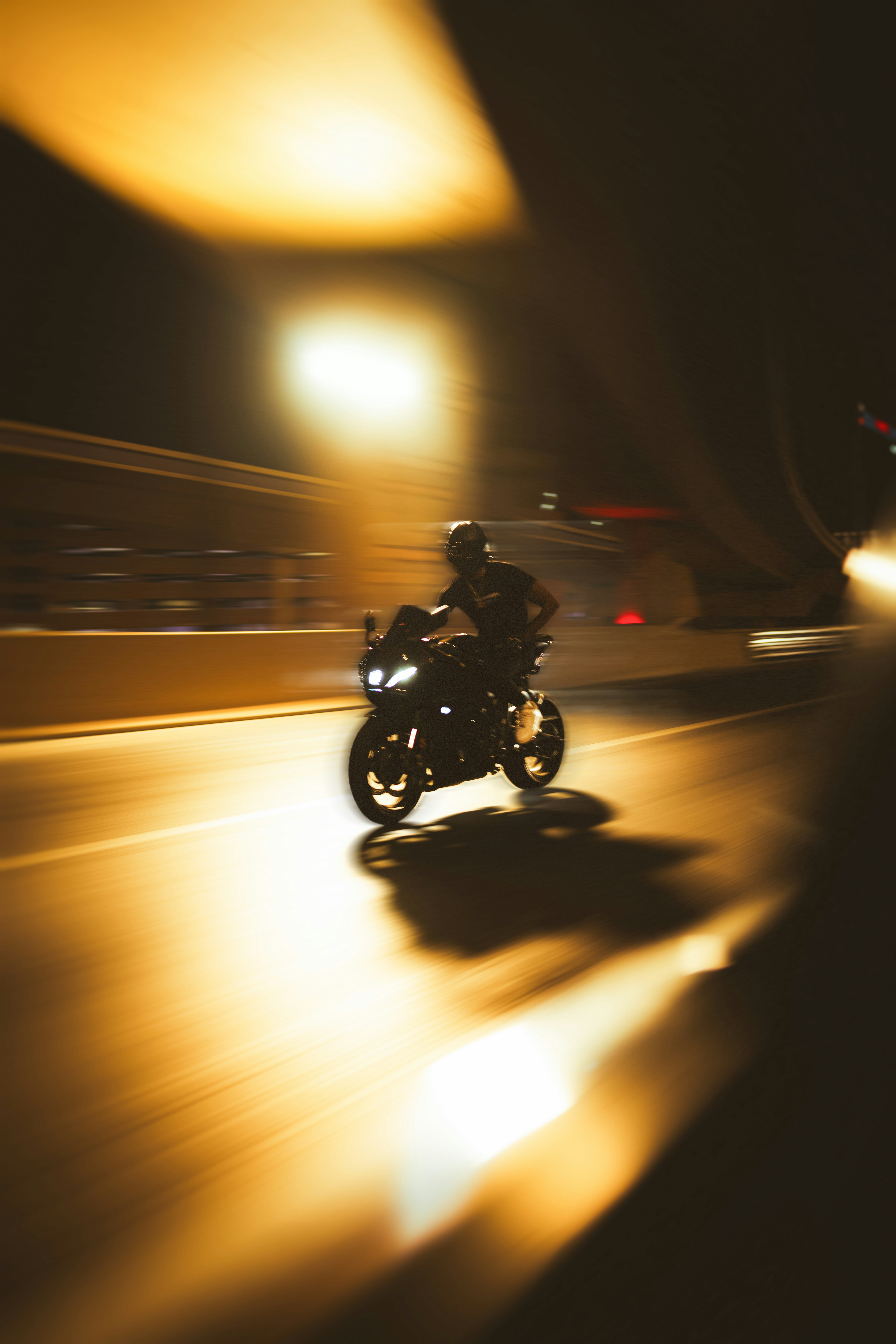 A man riding a motorcycle down a street at night photo – Free Usa Image ...