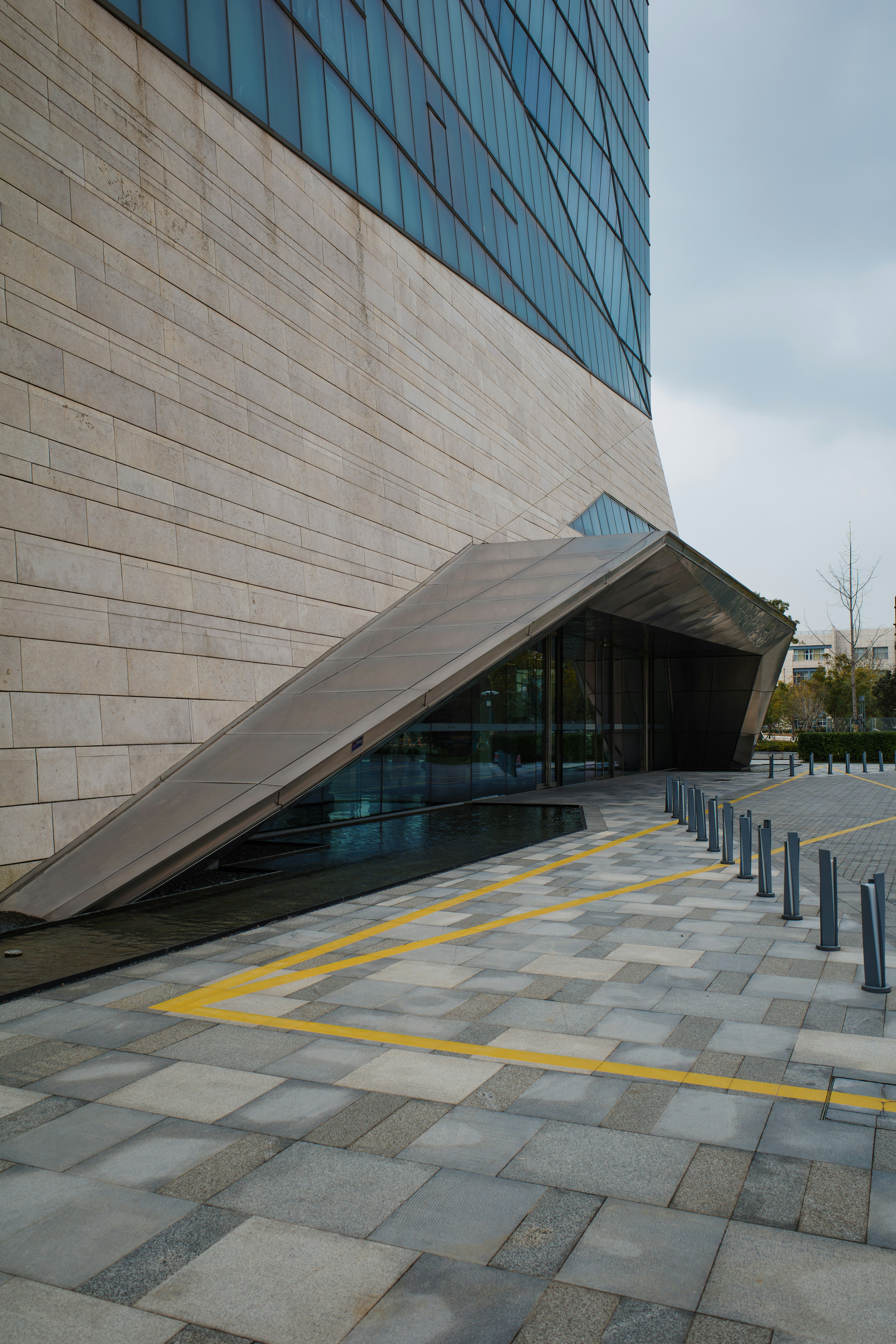 Tilted Canopy Framing the Glass-and-Stone Entrance