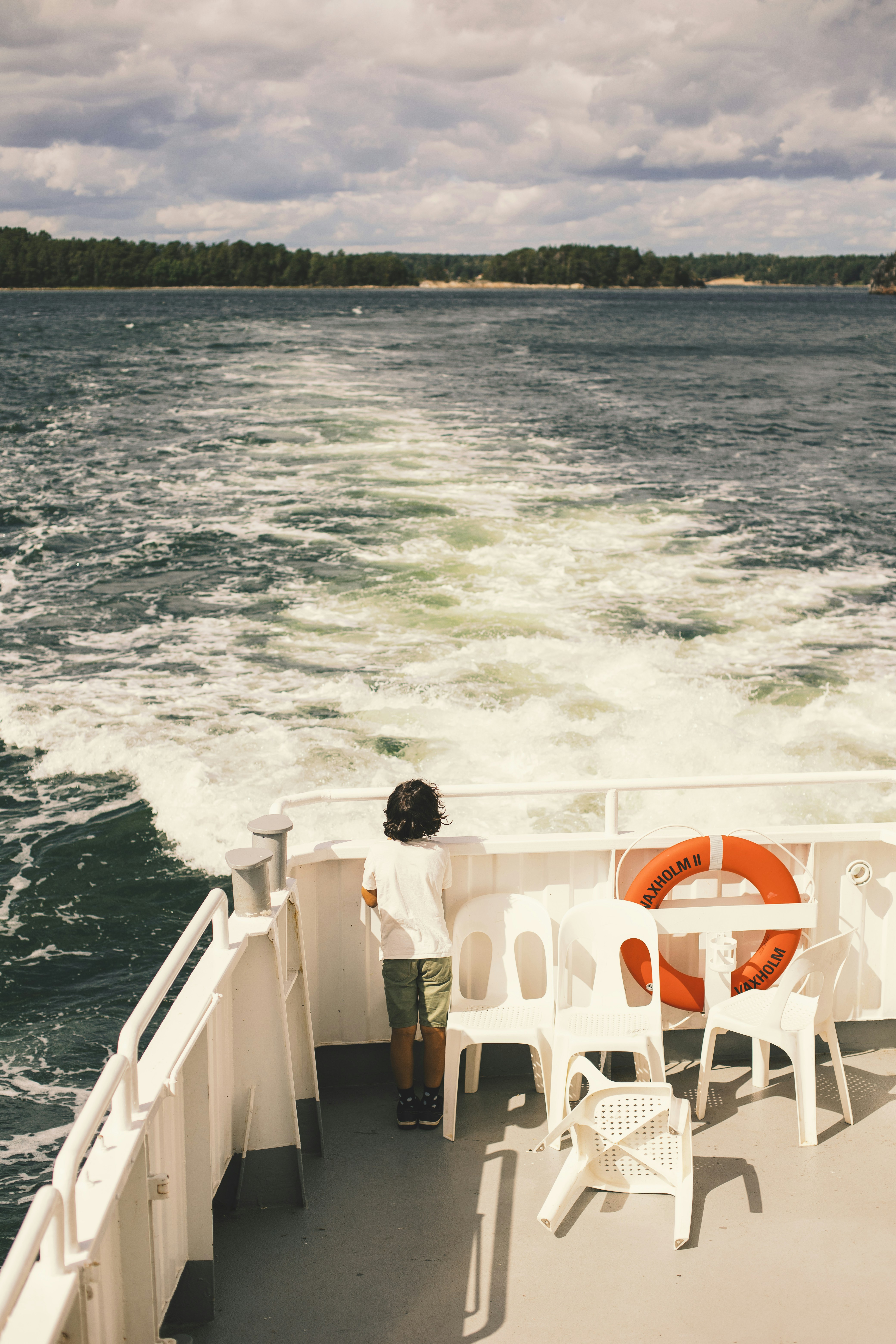 At the Rail, Watching the Wake: A Quiet Moment on the Open Water