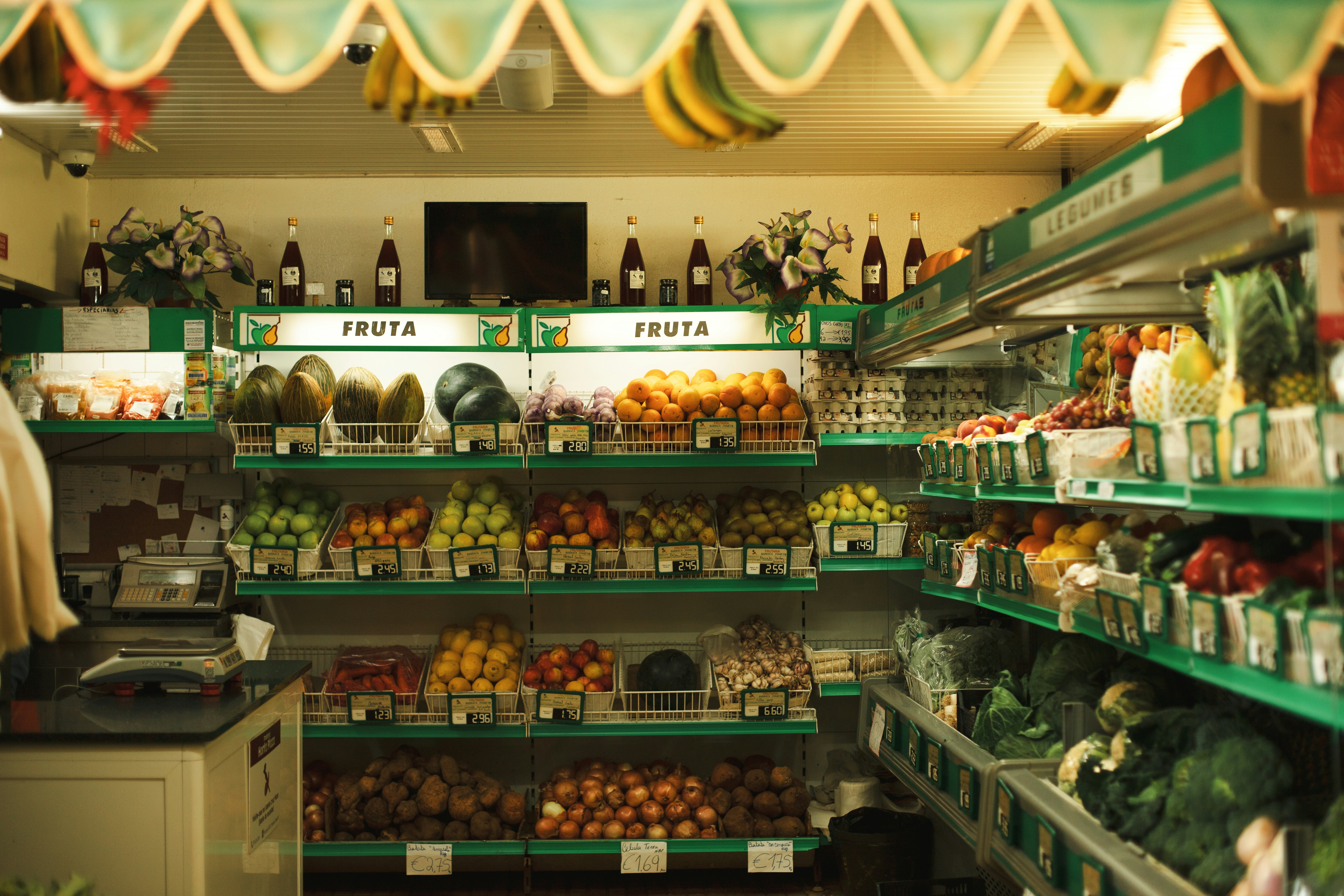 Cozy grocery store interior with neatly arranged fruits and vegetables on wooden shelves.