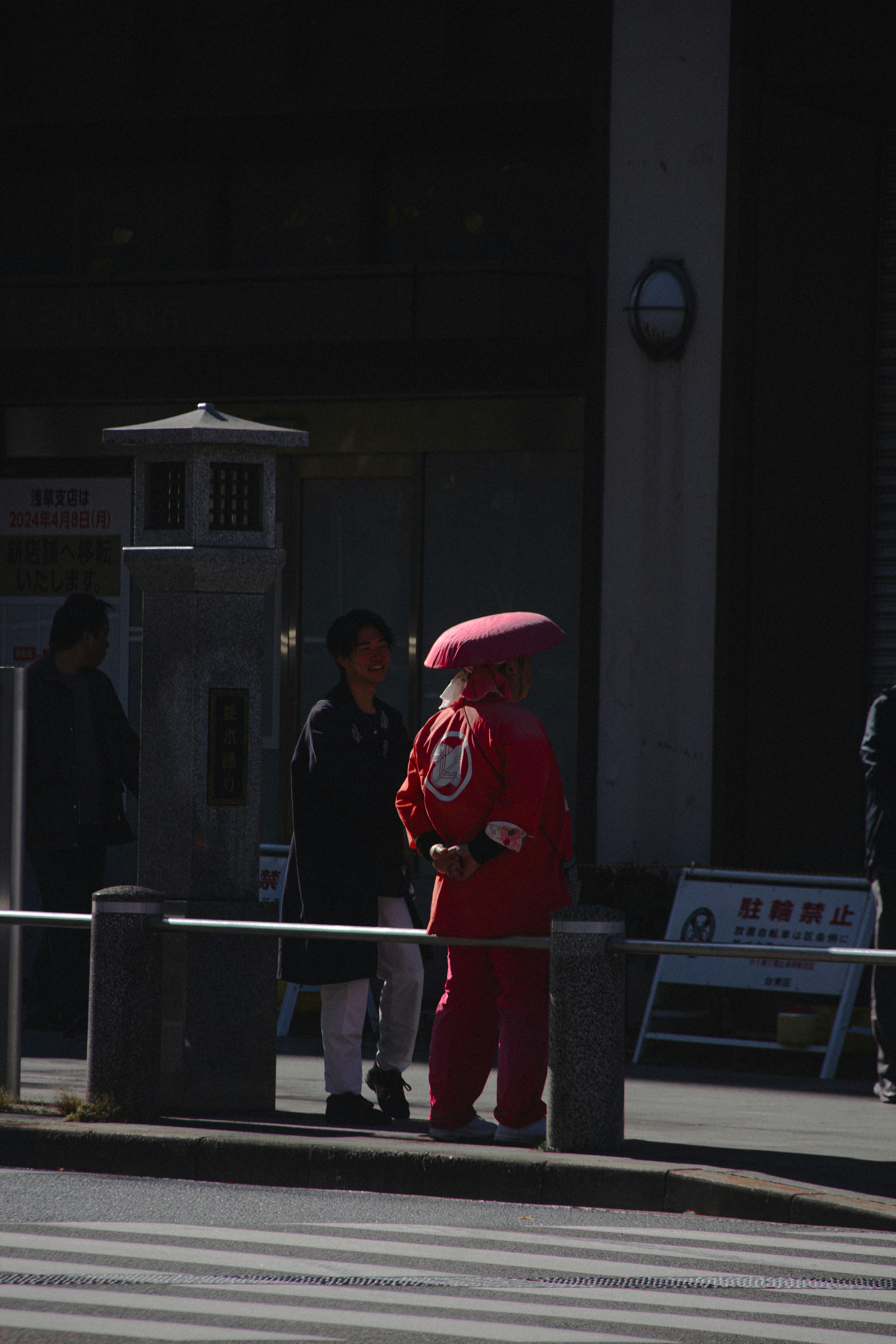 Crimson Parasol at the Edge of Light: A Quiet Street Portrait