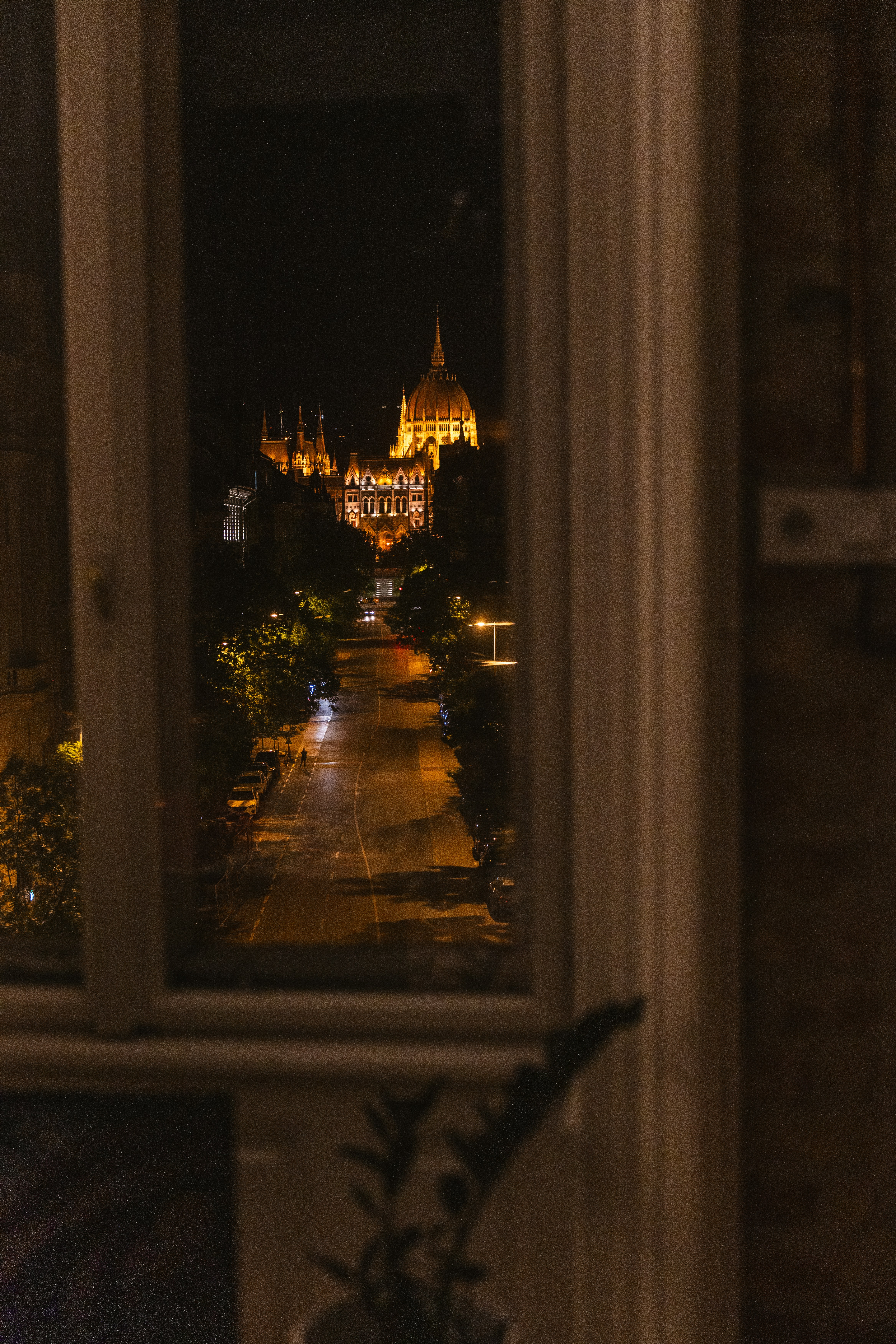 Window View: Golden Cathedral Rising Over a Quiet Night Street