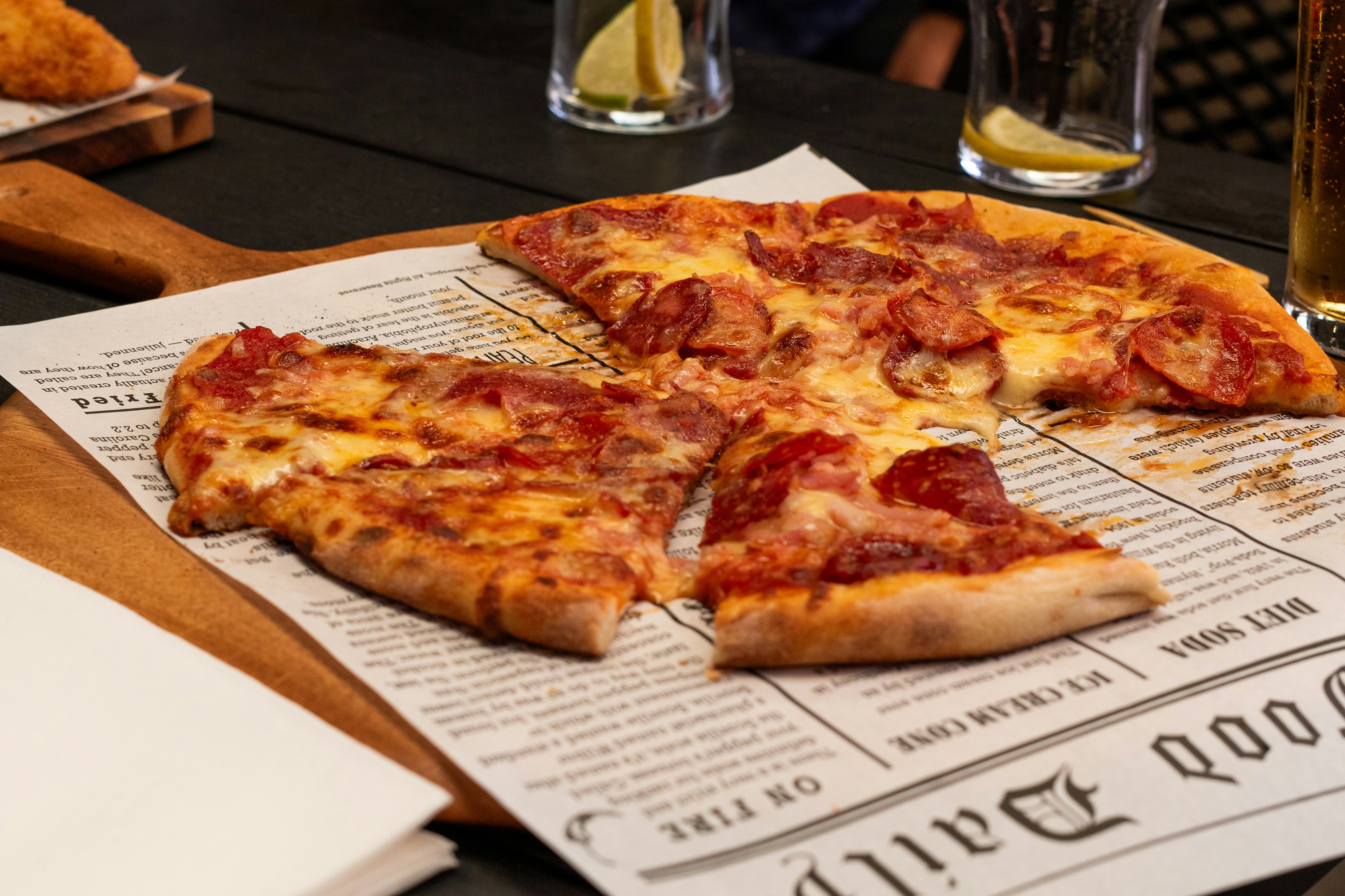 Pepperoni Crescendo: Slices Arranged on a Newspaper Spread