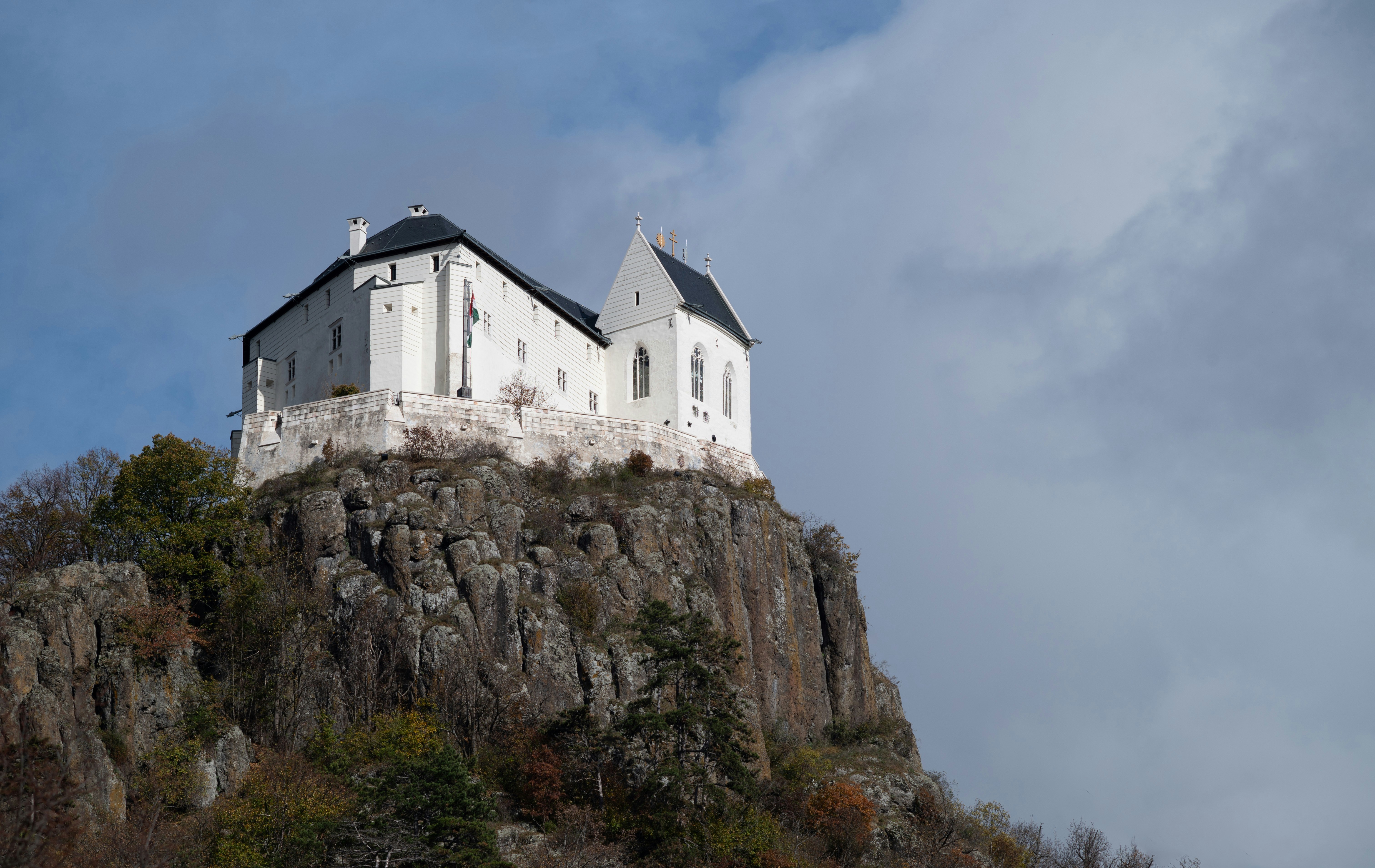 A white house on a hill with a blue sky in the backgroundNorbert Buduczki