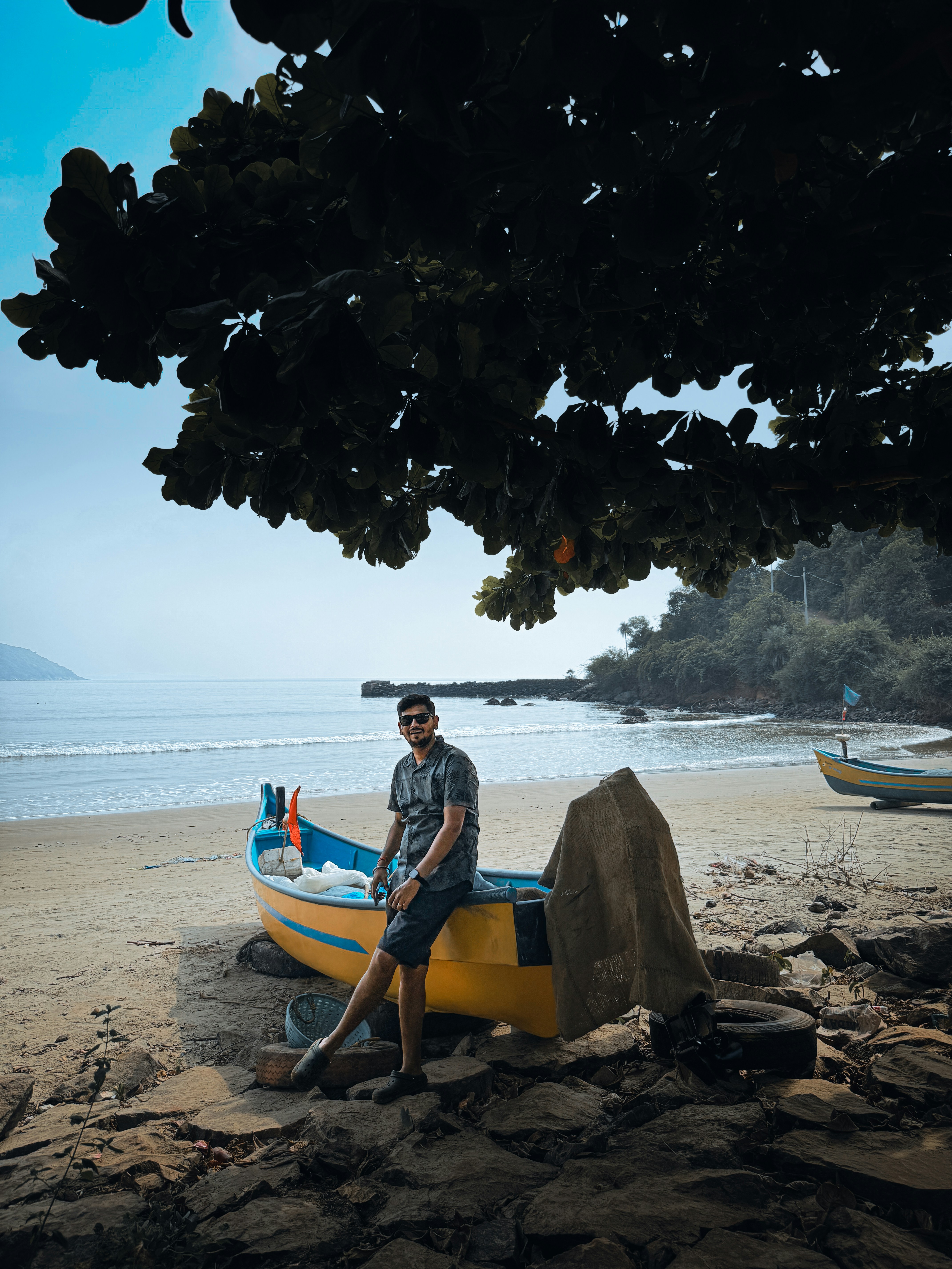 Shade, Sea, and a Yellow Boat: A Quiet Beach Moment