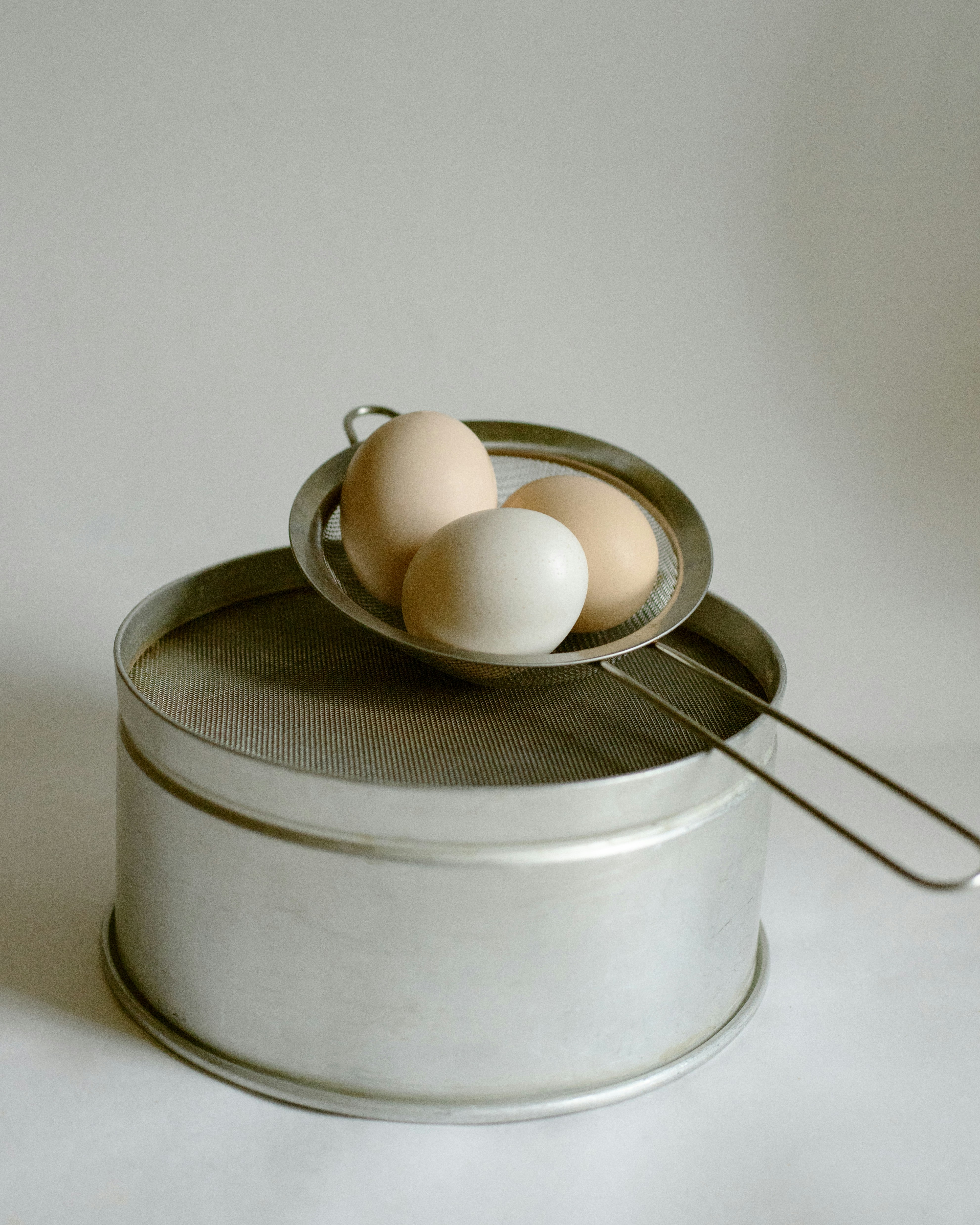 Three Eggs on a Metal Mesh: A Minimal Still-Life Study