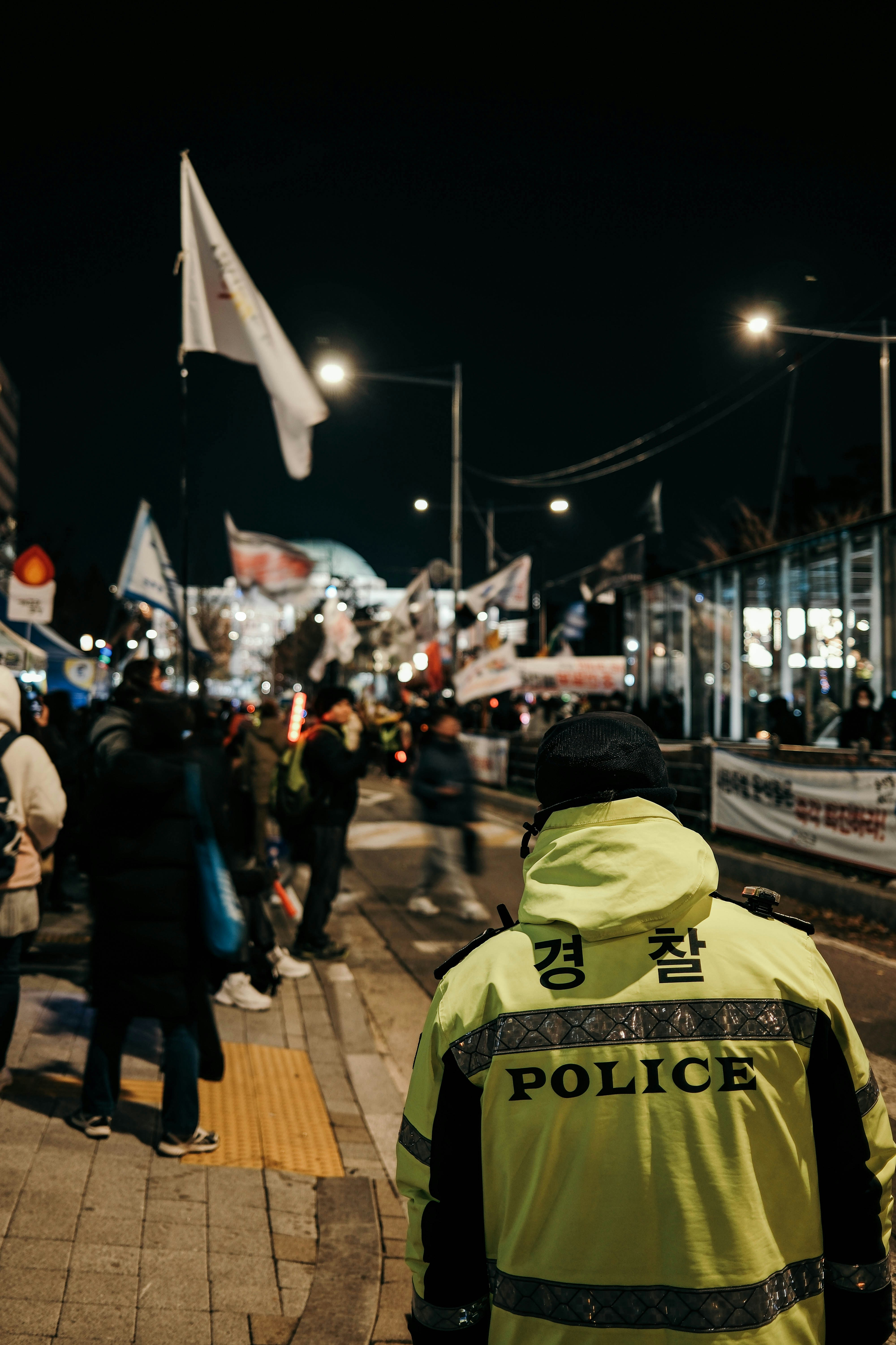 A police officer walking down a street at night photo – Free Photo ...