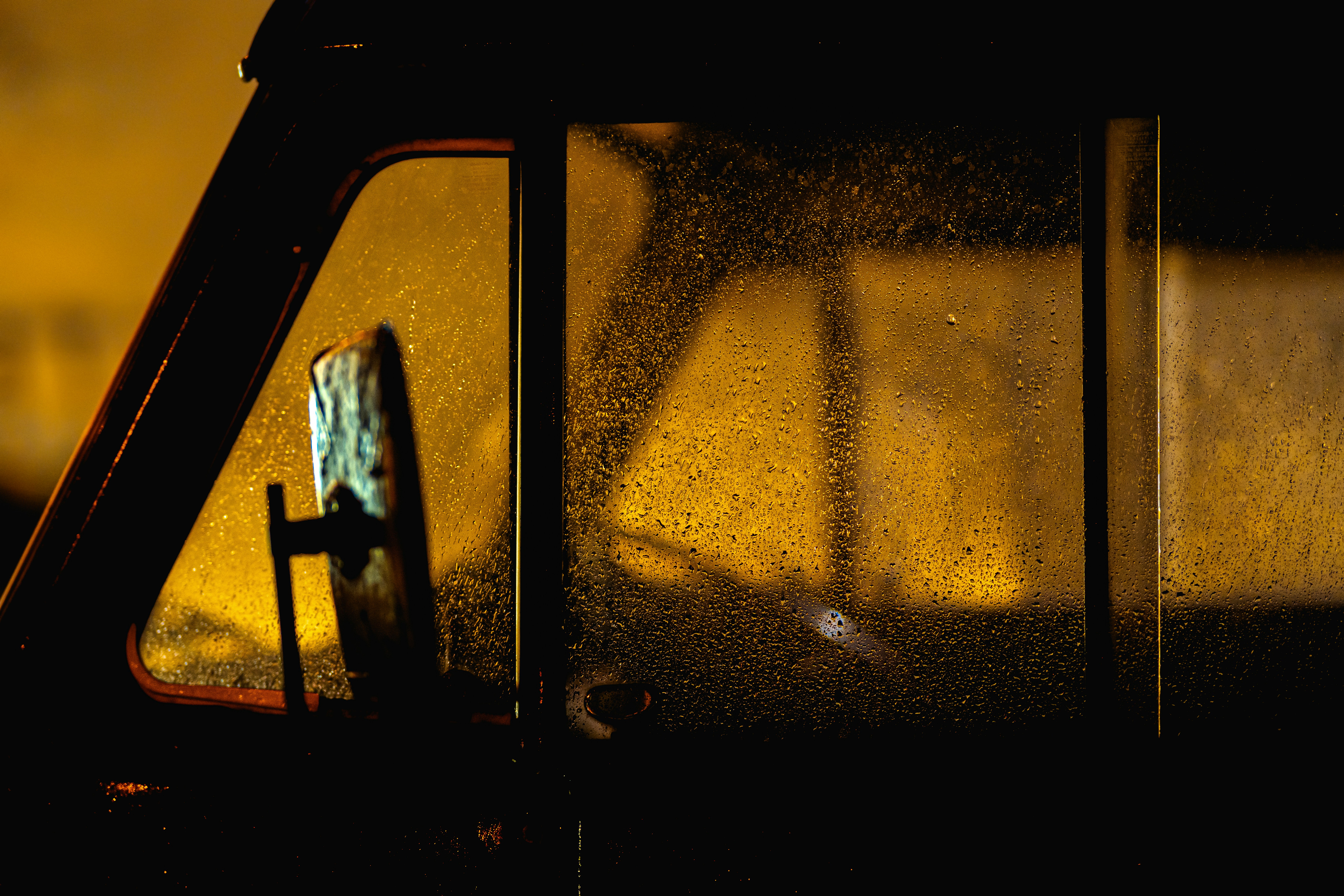 Amber Quiet: Rain-Kissed Window of a Van
