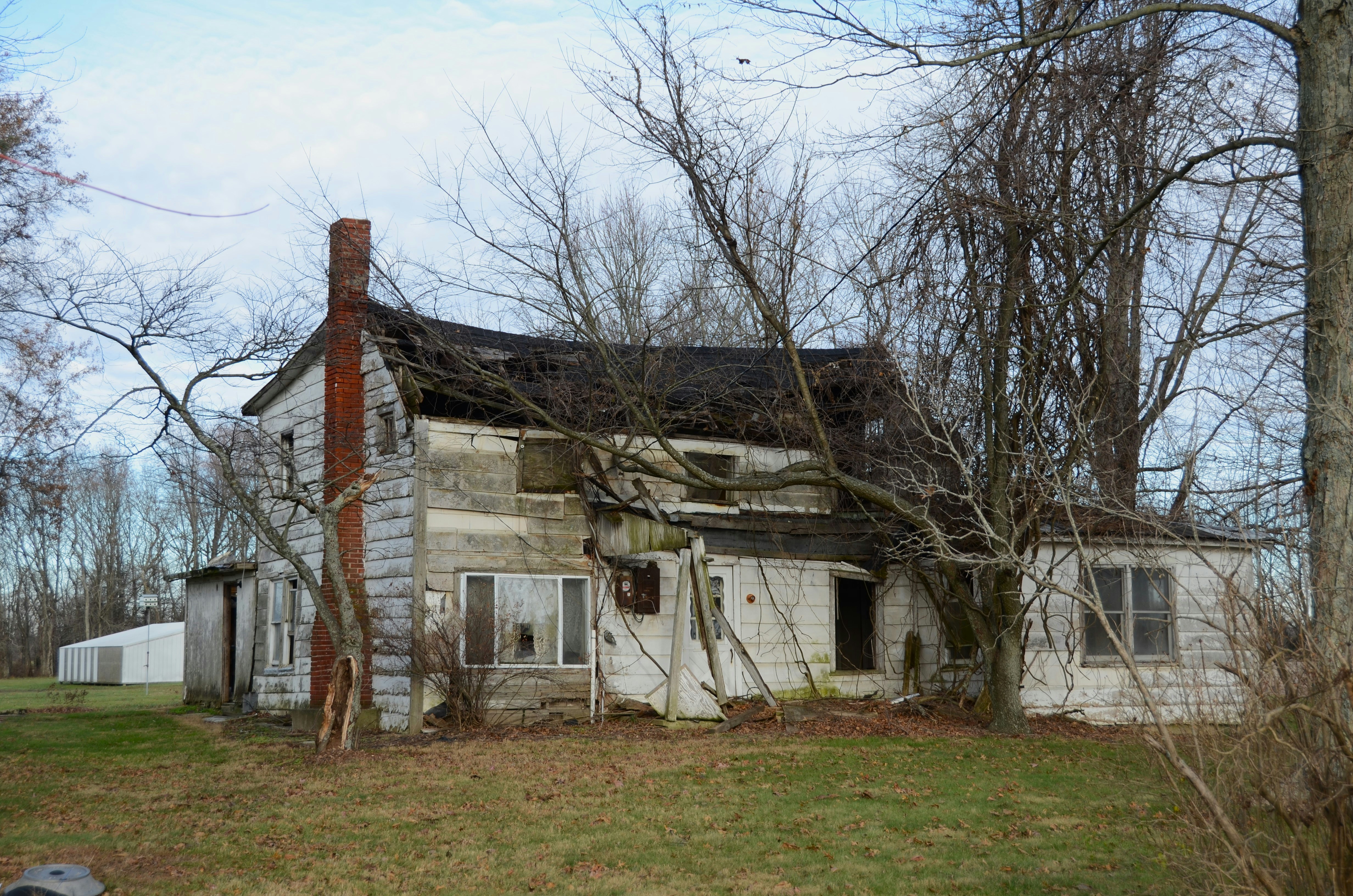 vacant and crumbling old frame farmhouse