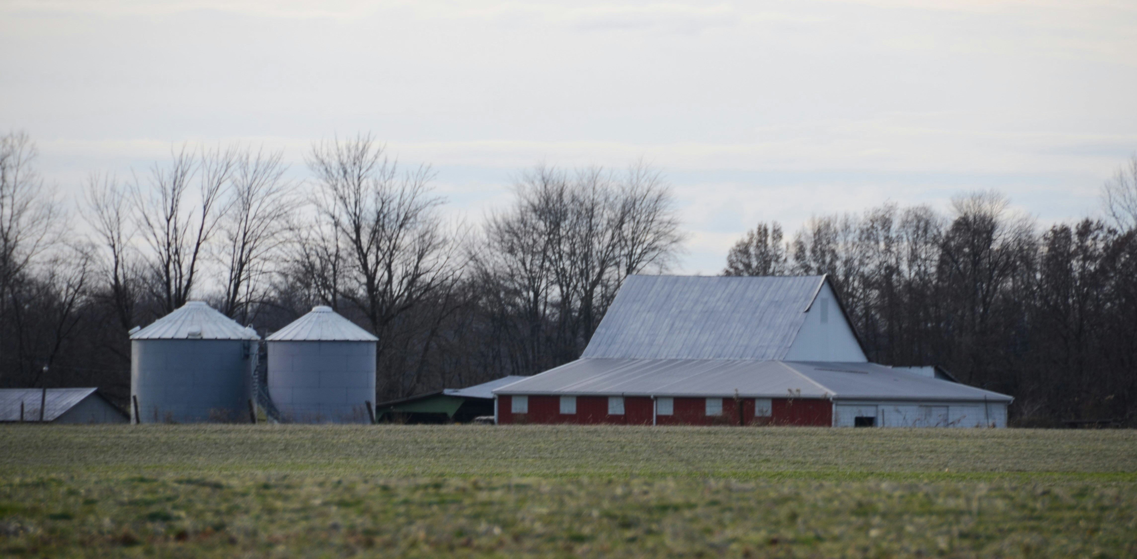 A farm with a barn and silos in the background photo – Free Farm Image ...