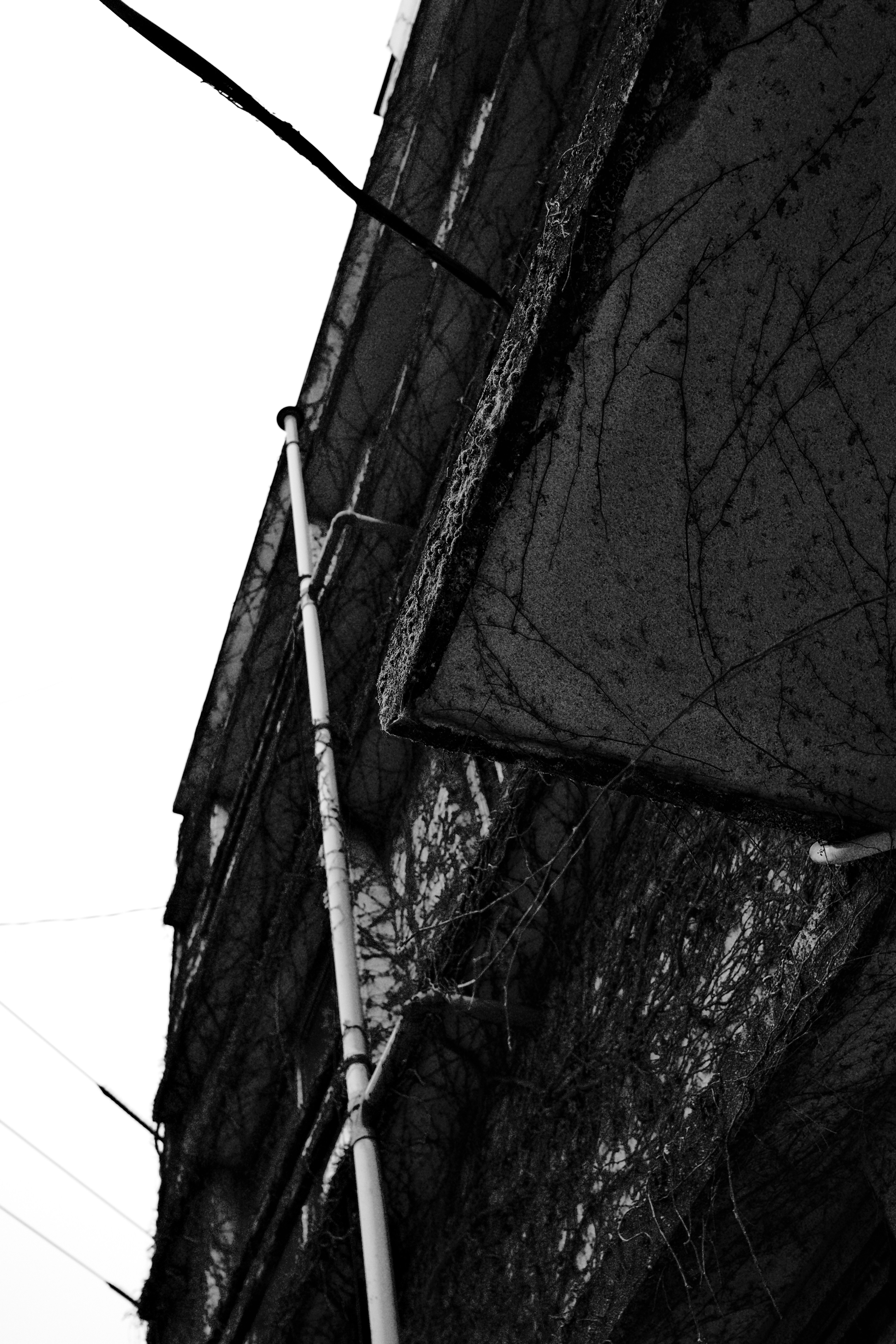 Urban Fracture: Weathered Brick Corner Framed by Tangled Cables