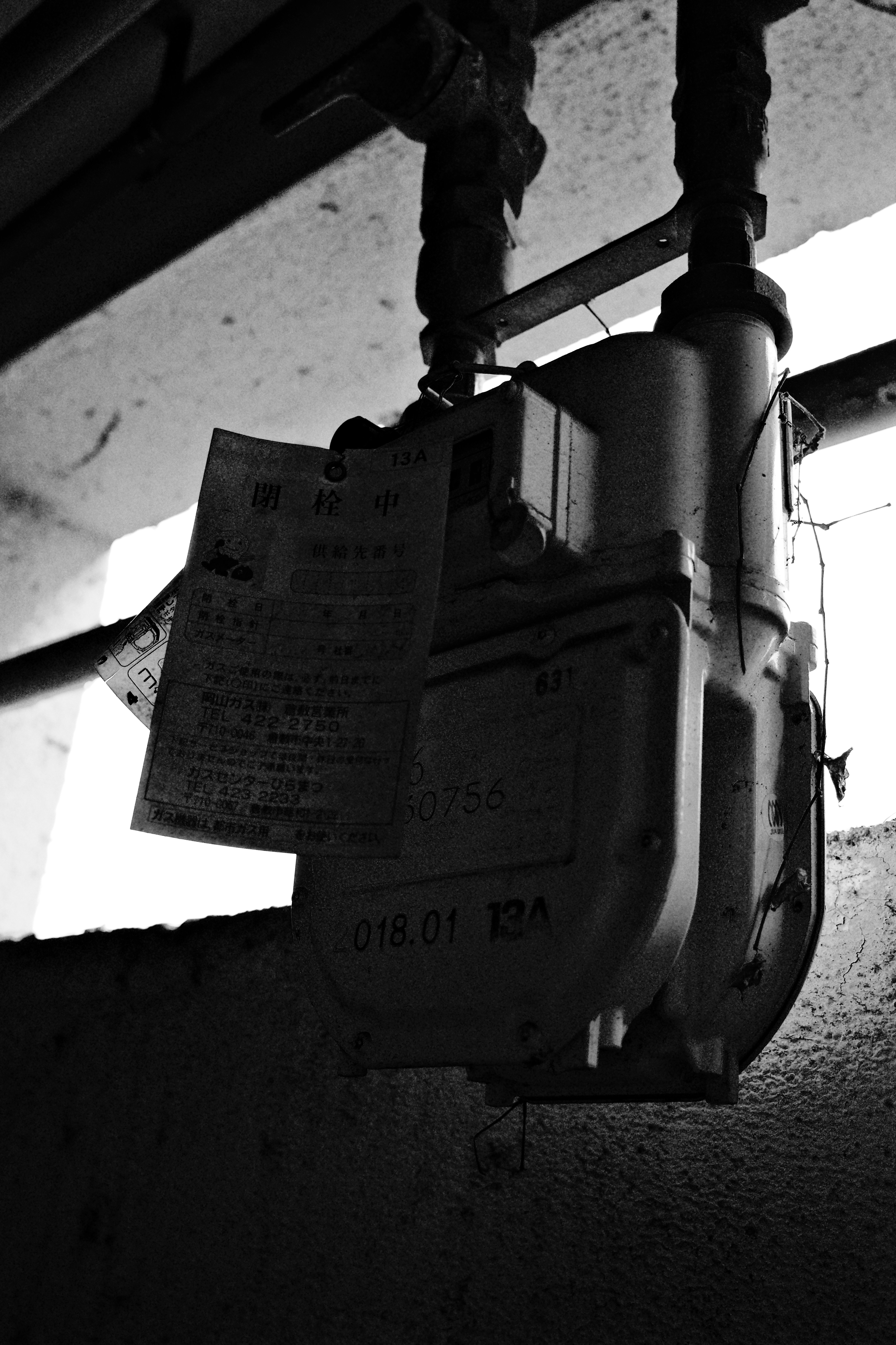 Conduit Portrait: The Weathered Gas Meter in a Dim Concrete Corridor