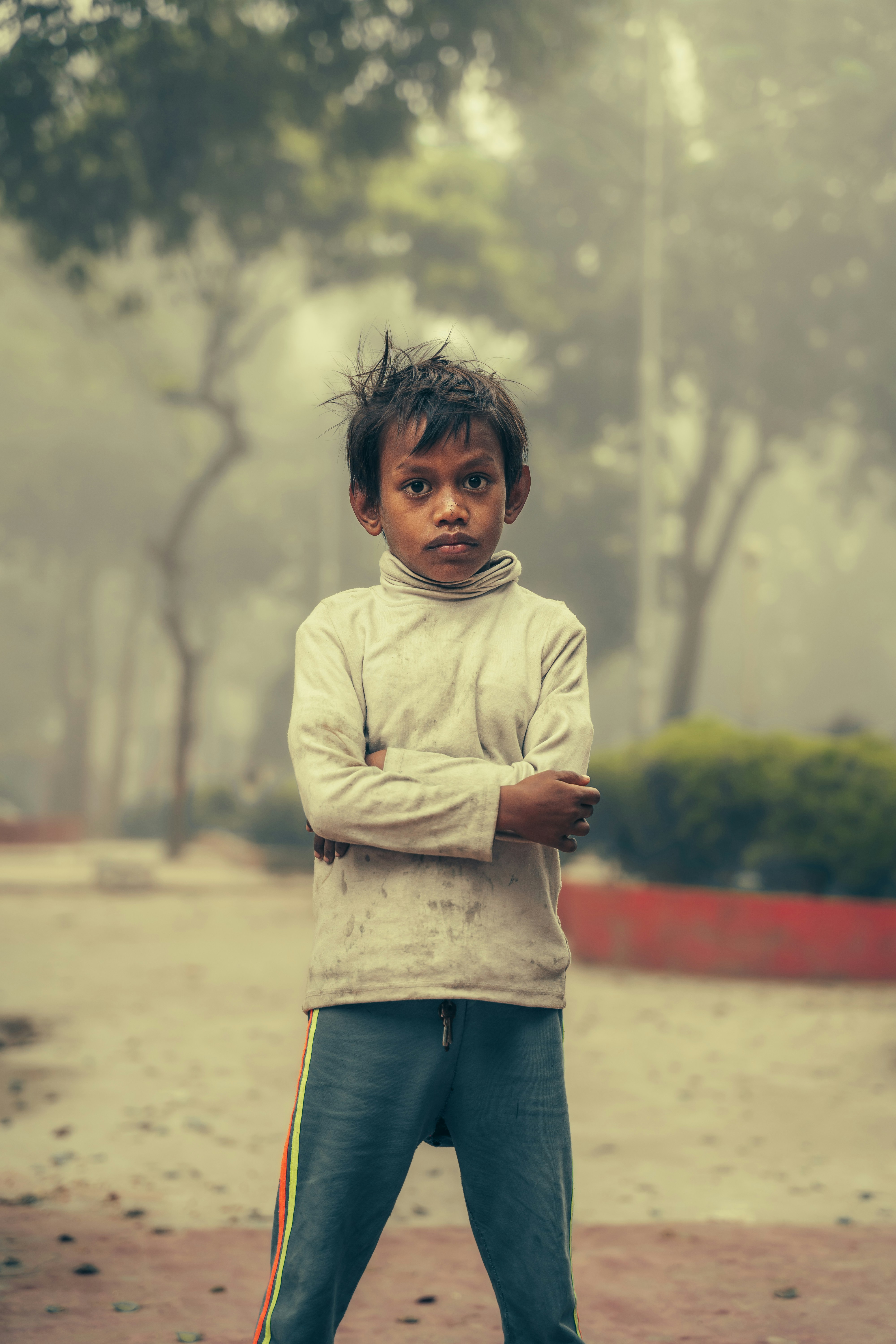 A young boy standing in the rain with his arms crossed photo – Free Comilla Image on Unsplash