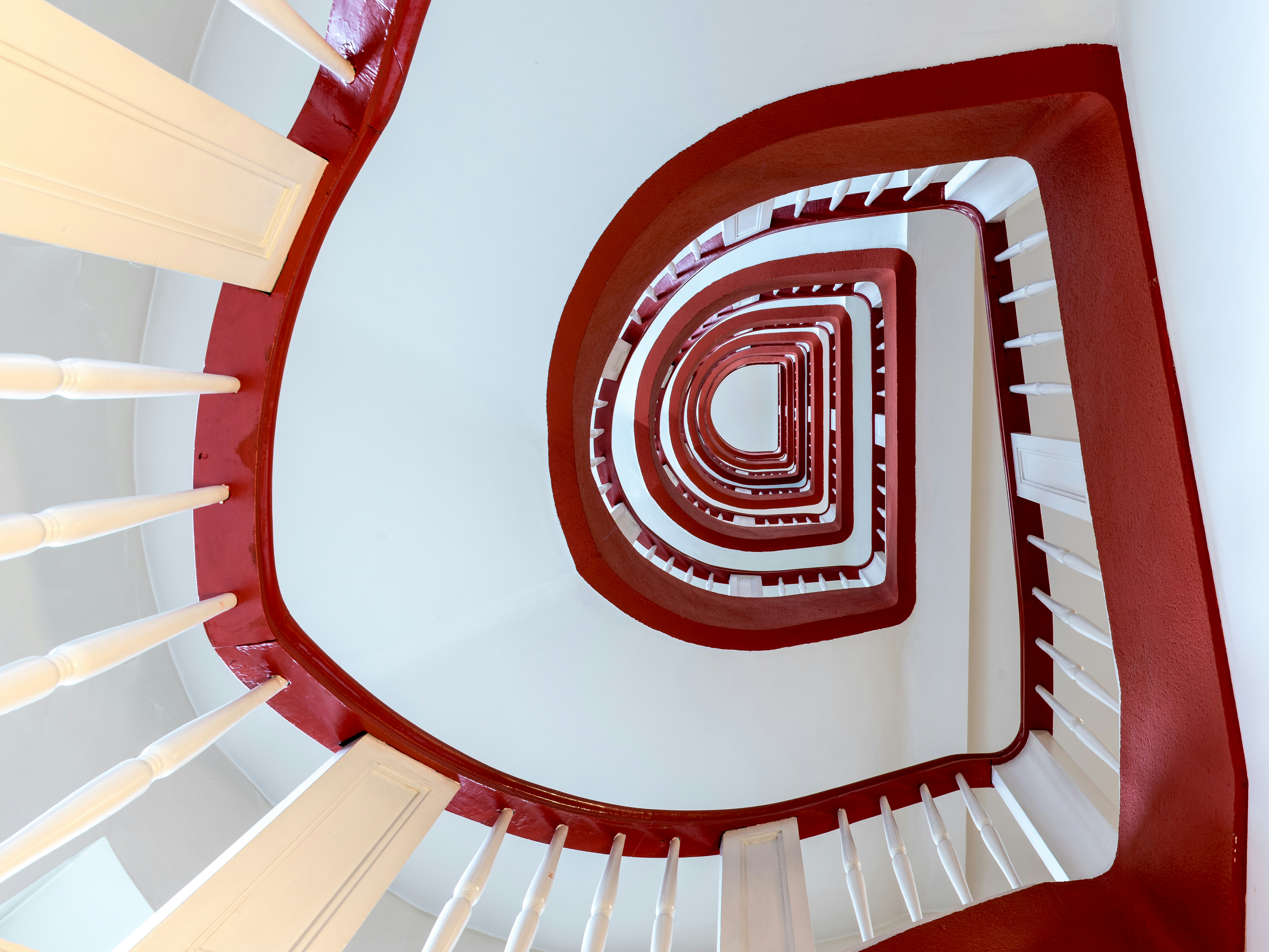 Spiral Descent: A Red Stairwell Reaches For the Sky