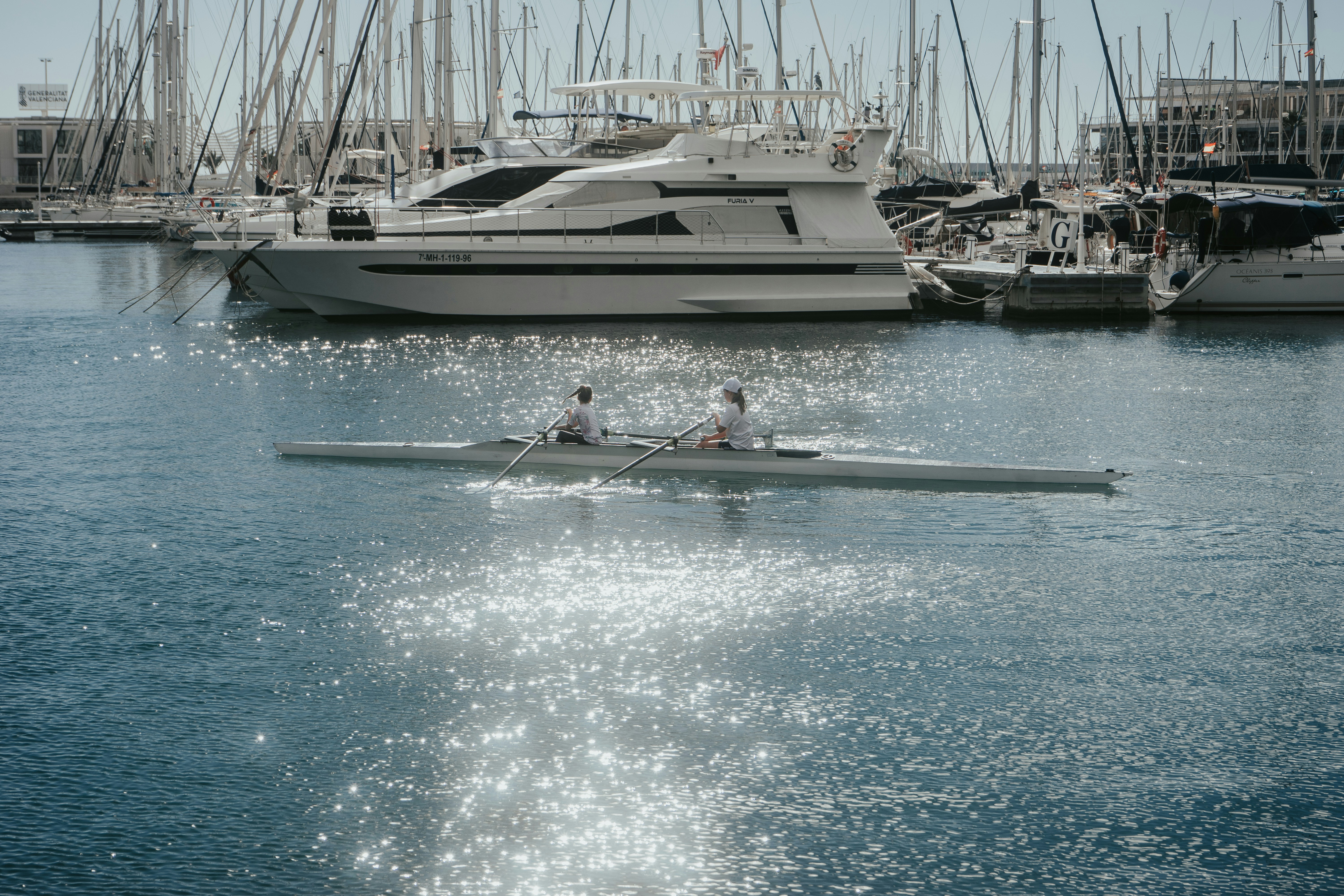 Twin Oars Across a Glittering Marina