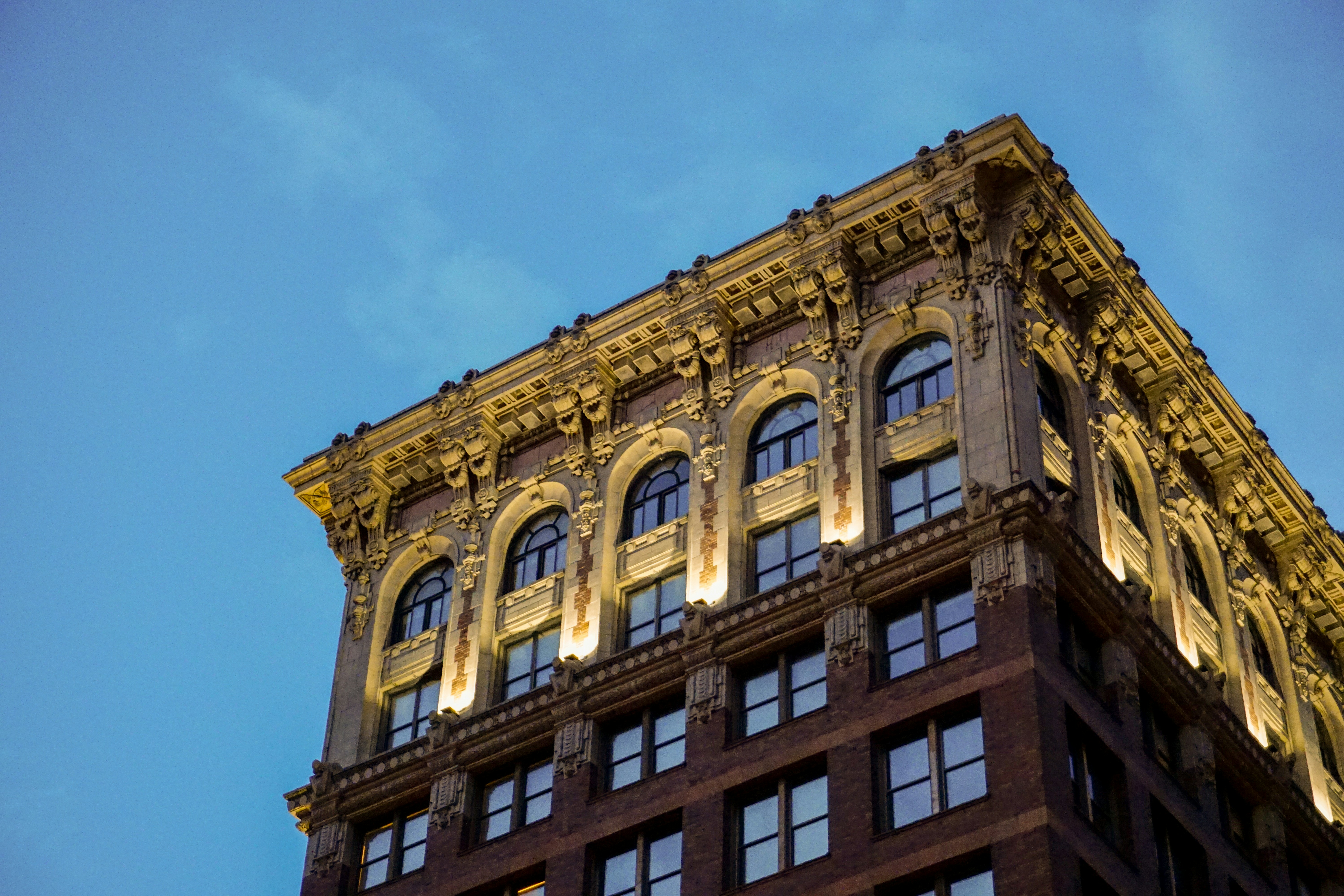 Ornate building facade illuminated against a twilight sky.