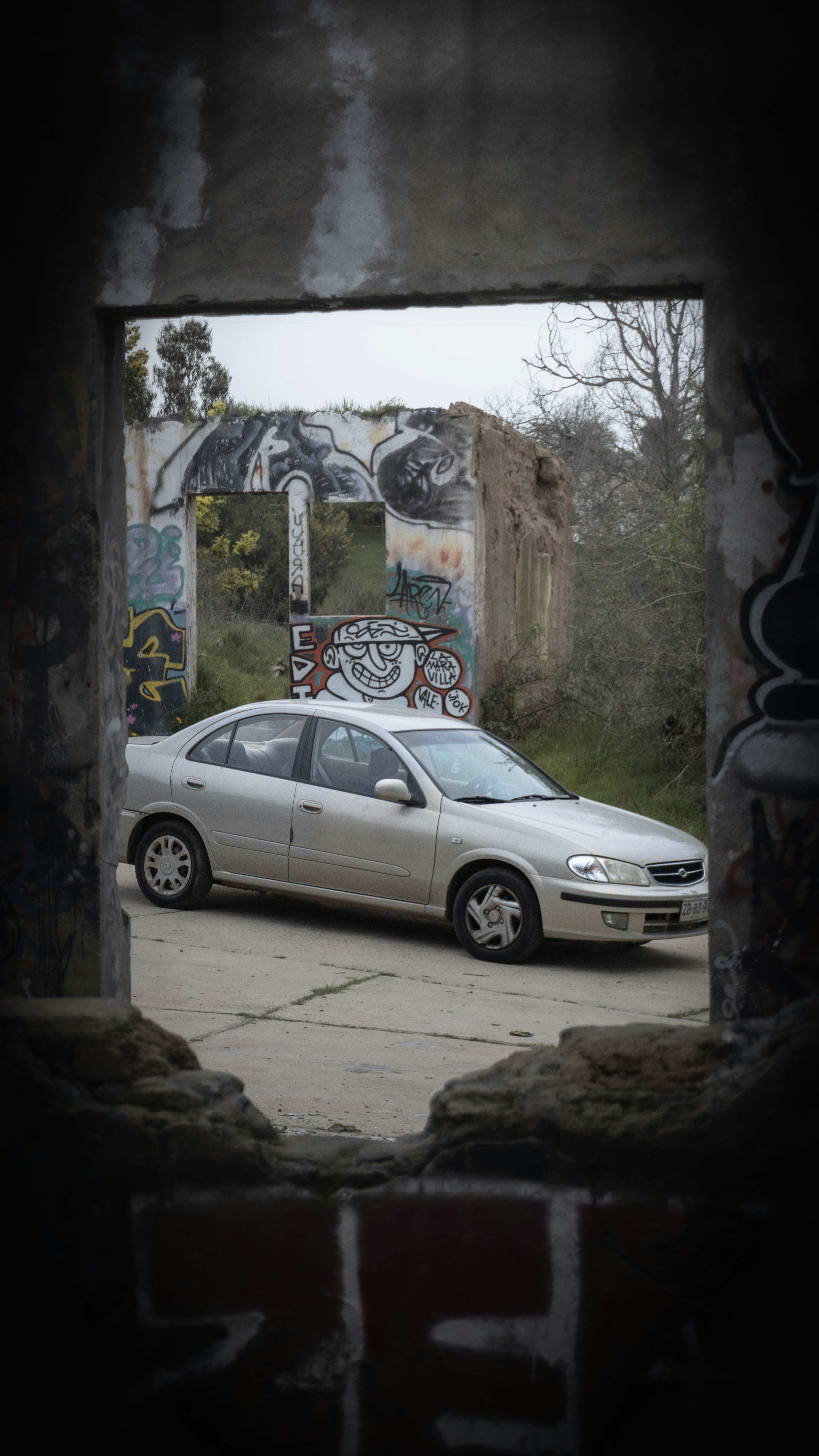 Graffiti Frame: Silver Sedan Anchored by Urban Wall Art
