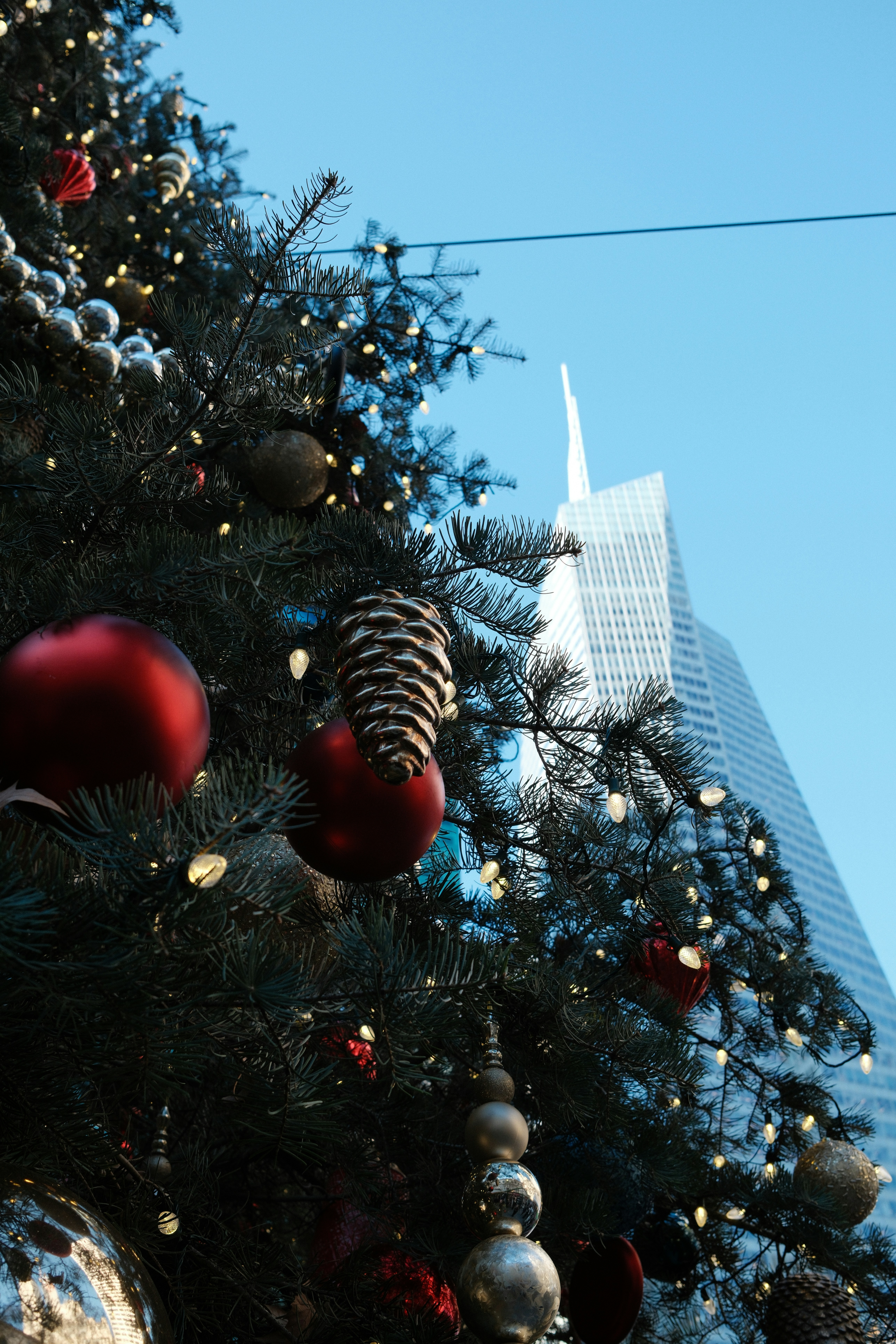 A christmas tree with ornaments and a skyscraper in the background