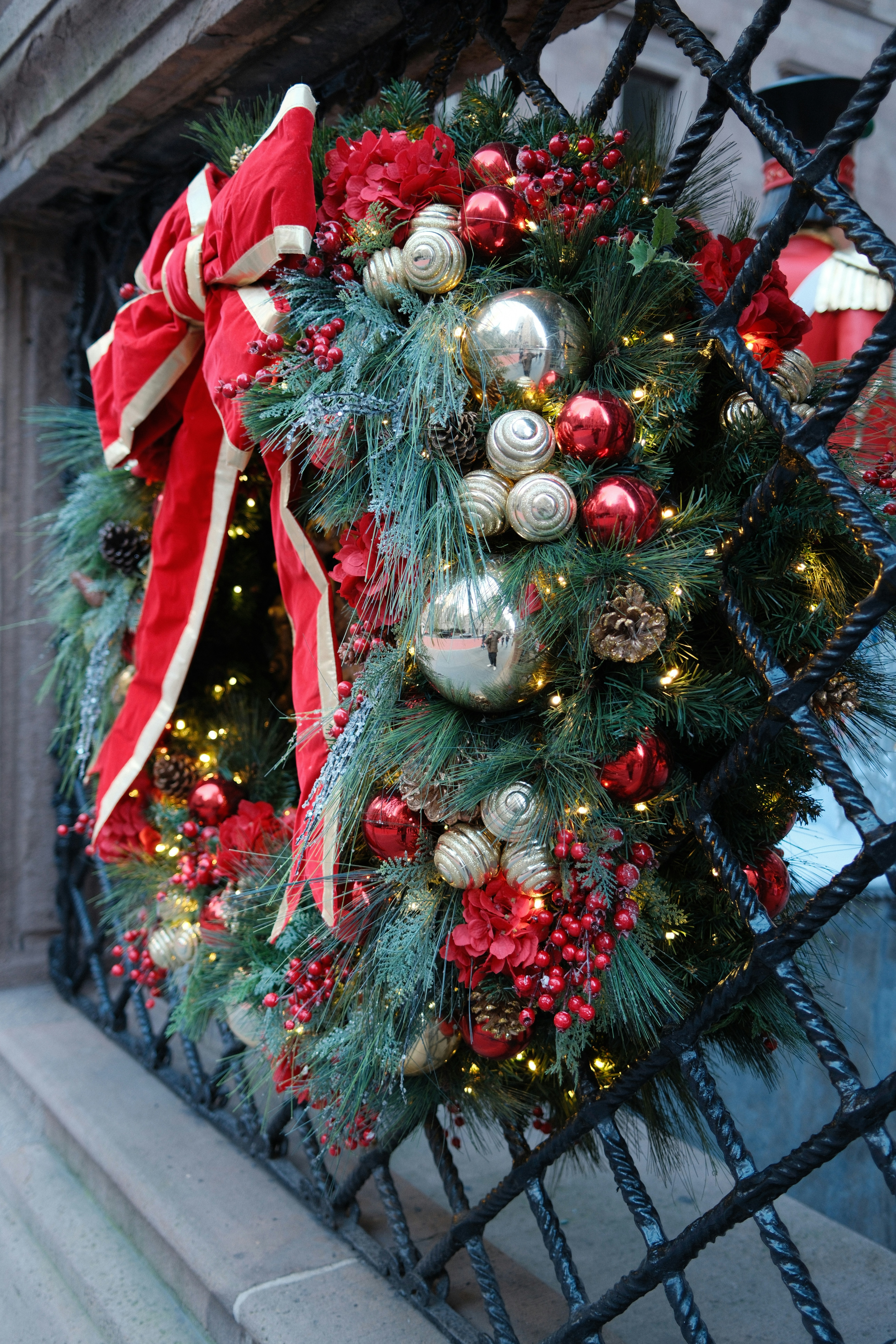 Shimmering Ornaments on a Holiday Wreath Framed by Wrought Iron