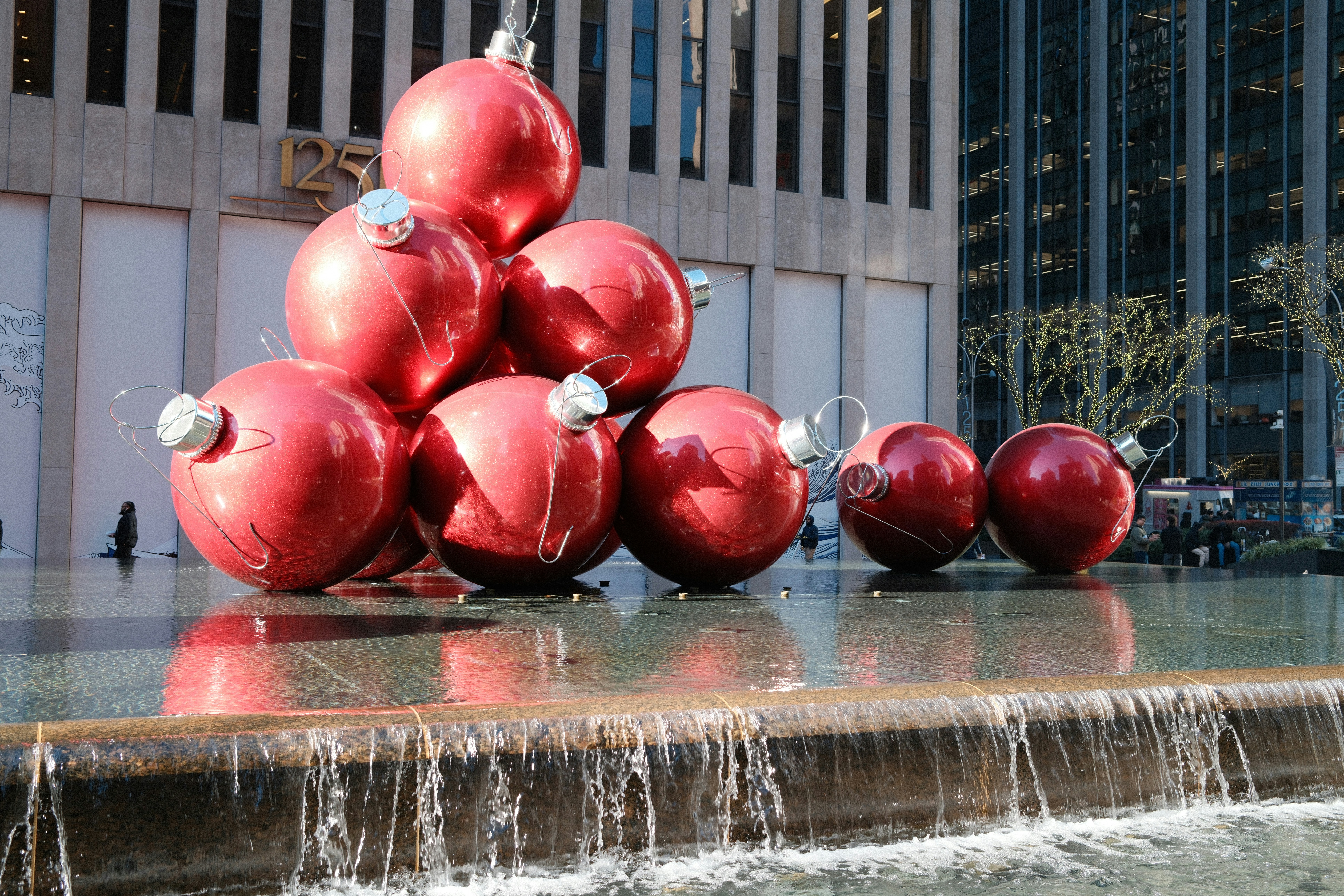 Floating Christmas Orbs: A Cluster of Red Ornaments Anchored by a Waterfall
