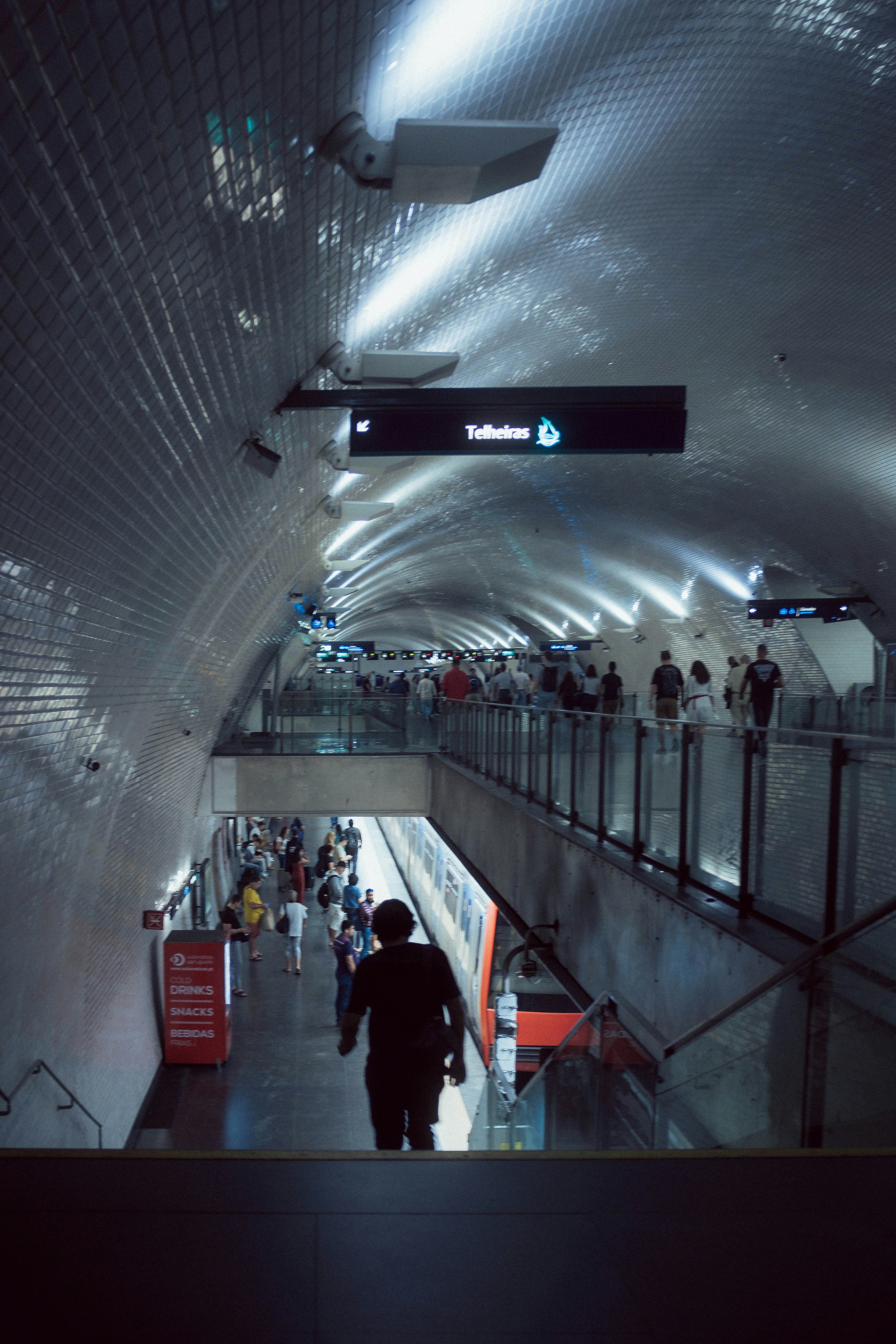 Blue Arches and Moving Lines: Commuters in a Neon-Blue Metro Hall
