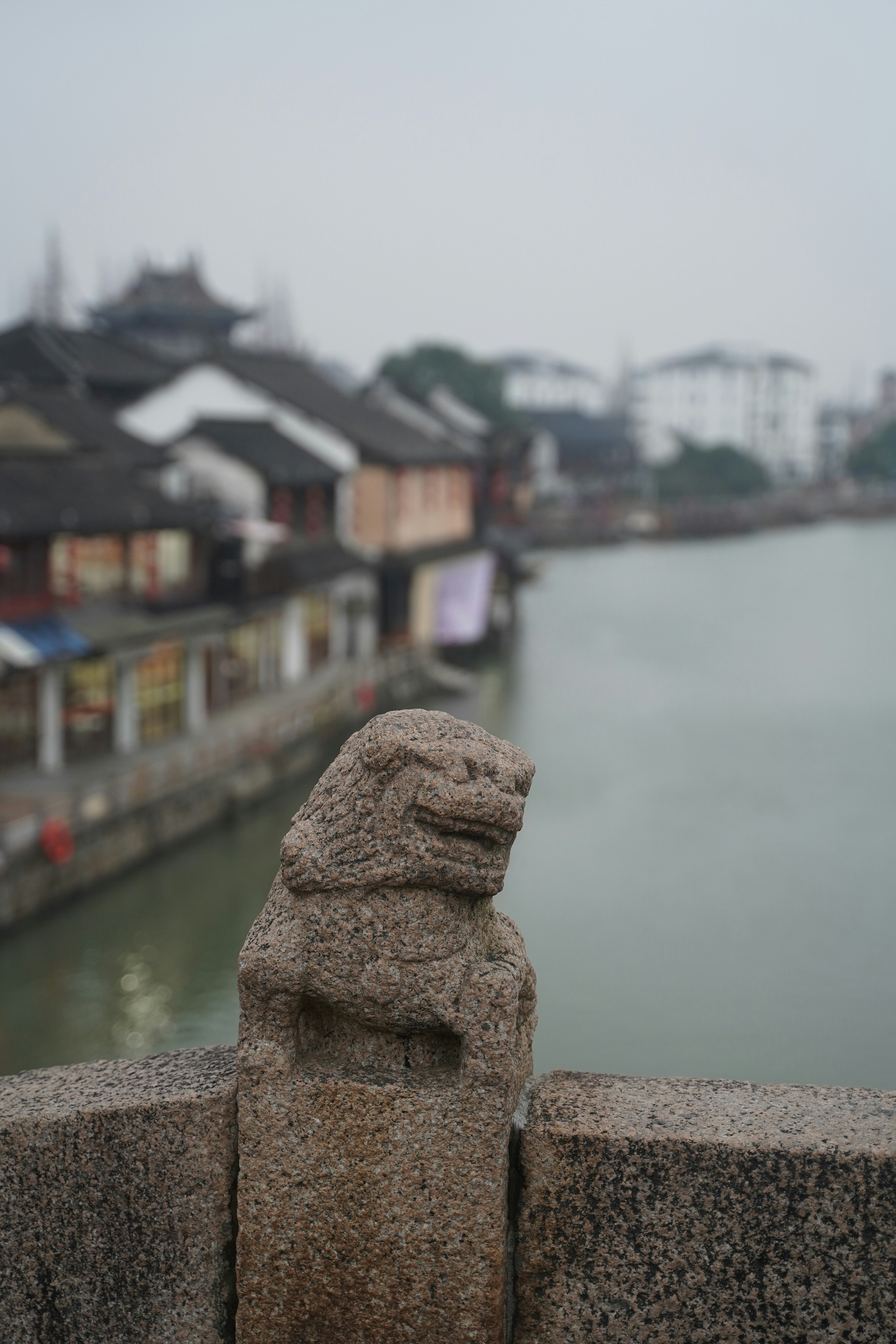 Stone Guardian on a Quiet Canalfront Bridge