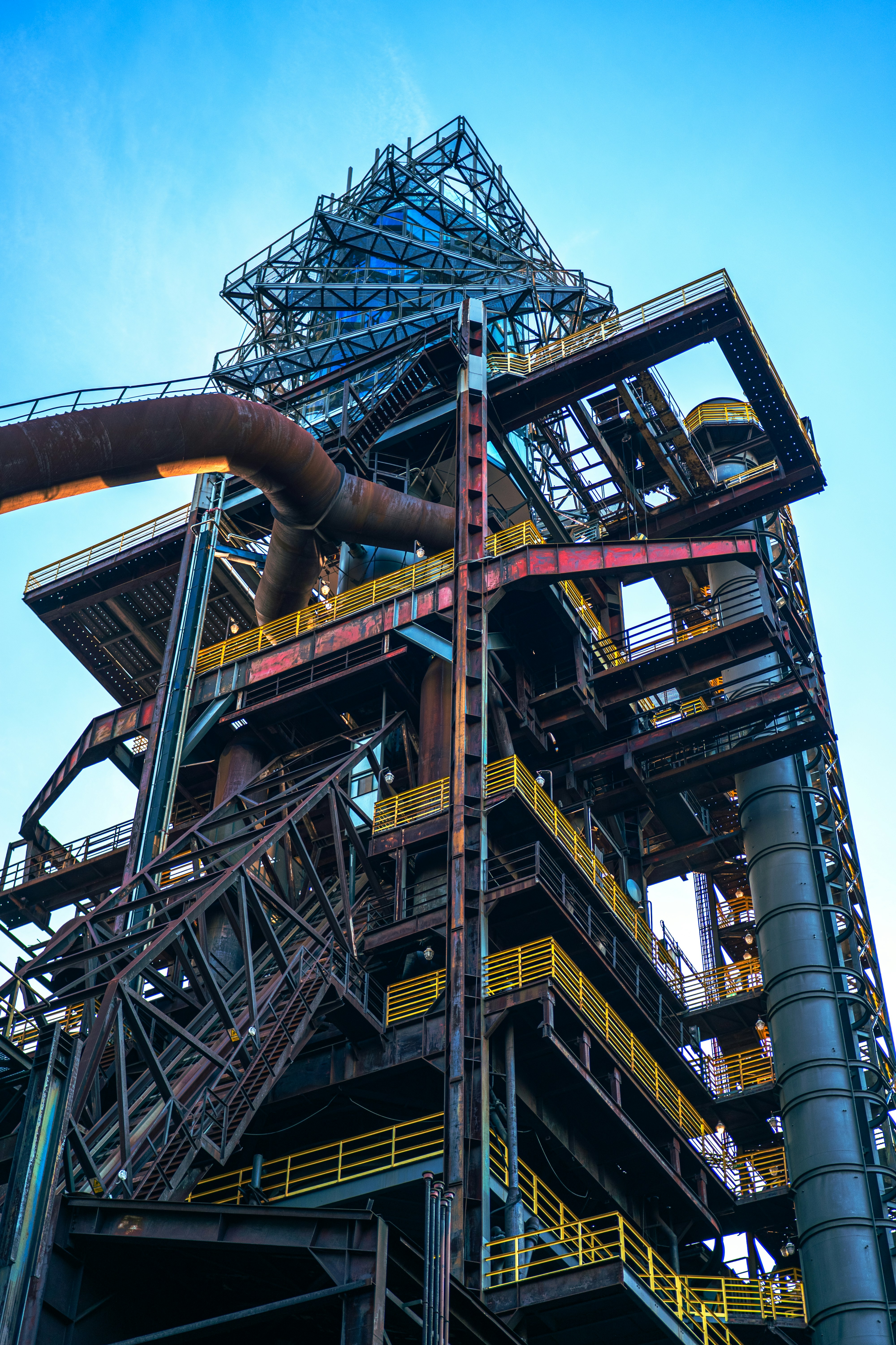 A very tall building with a lot of pipes photo – Free Bolt tower Image ...