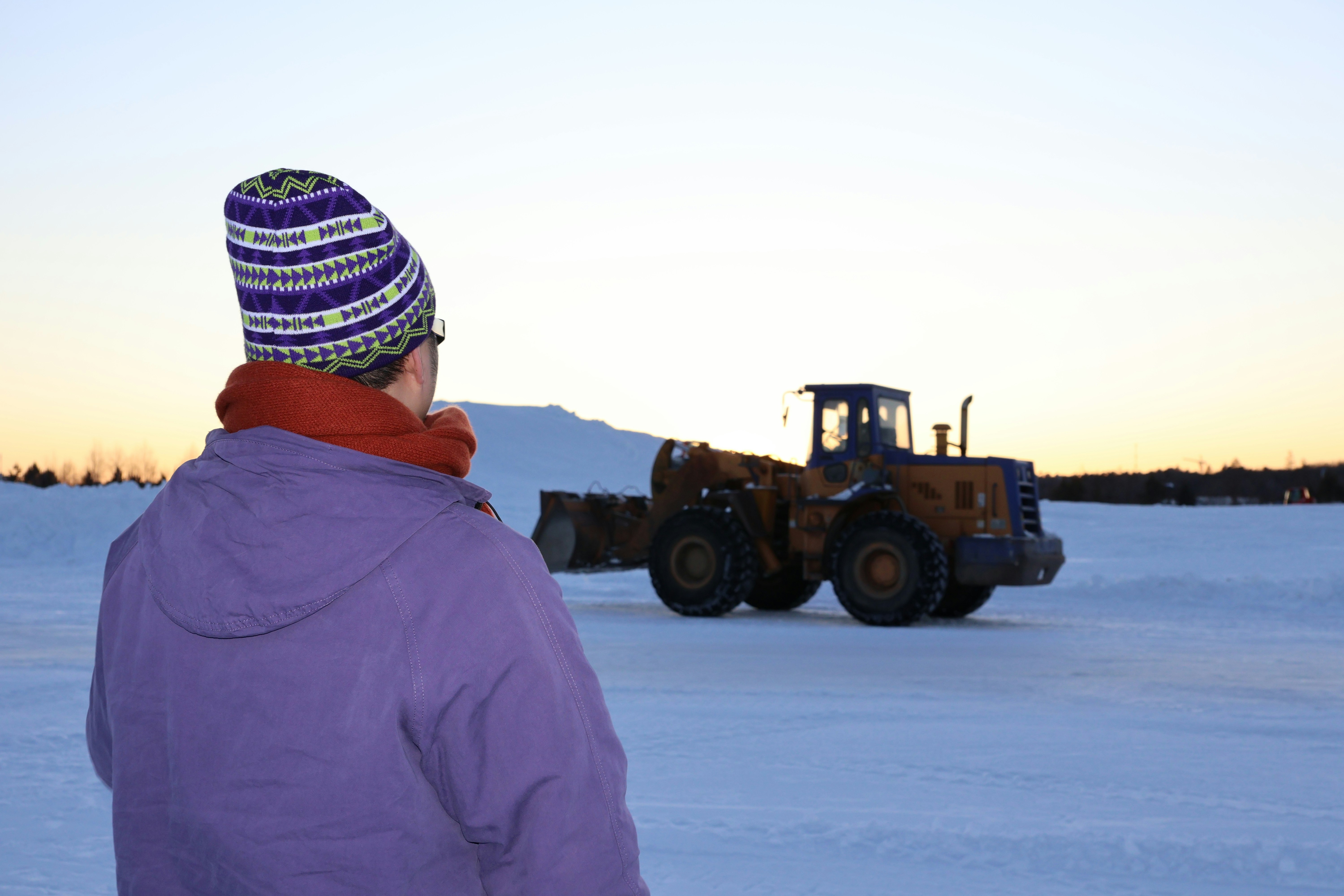 Cold Dawn, Quiet Presence: A Person in Lavender Under a Snowfield Sky