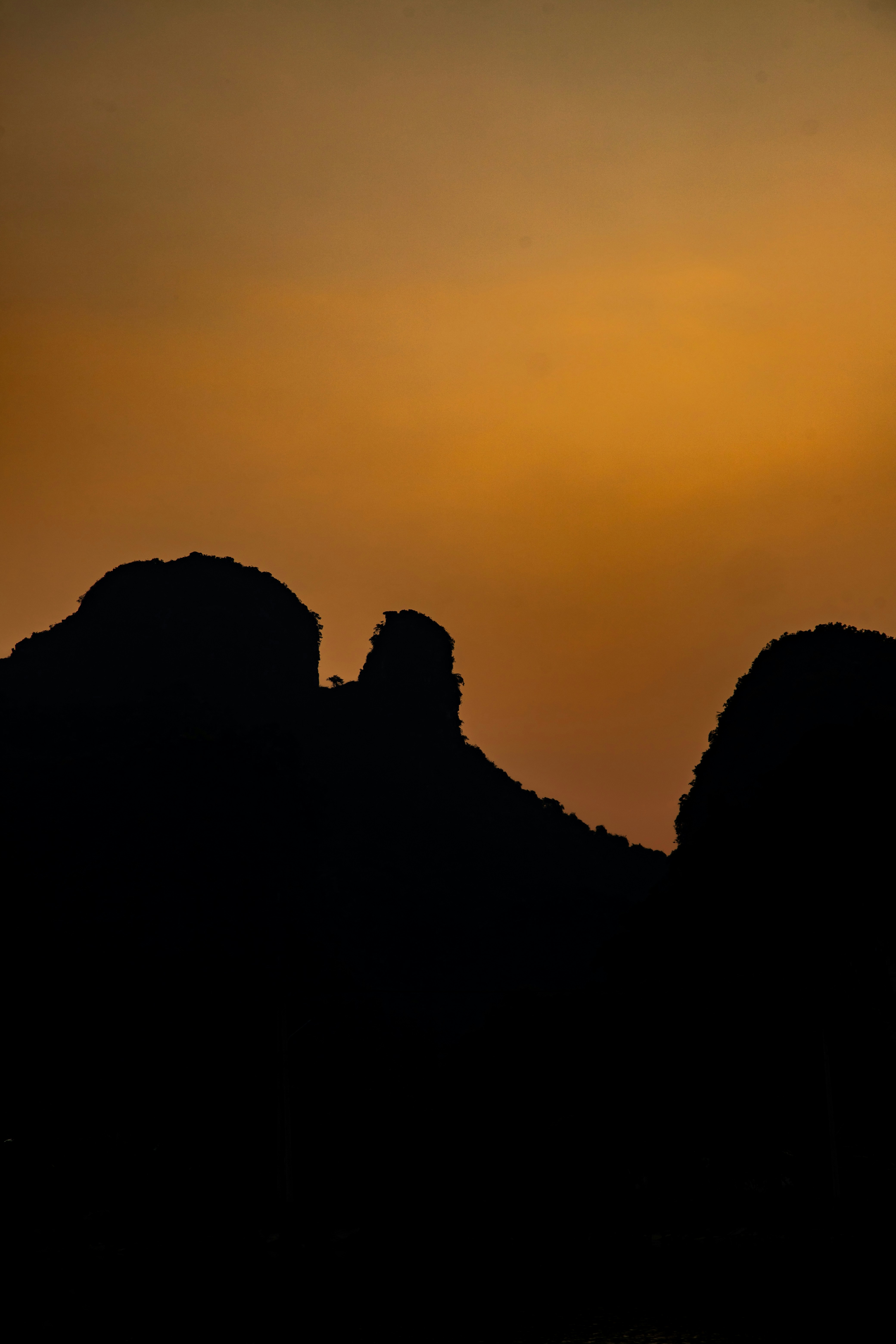 Crimson Sunset Behind Silhouetted Cliffs