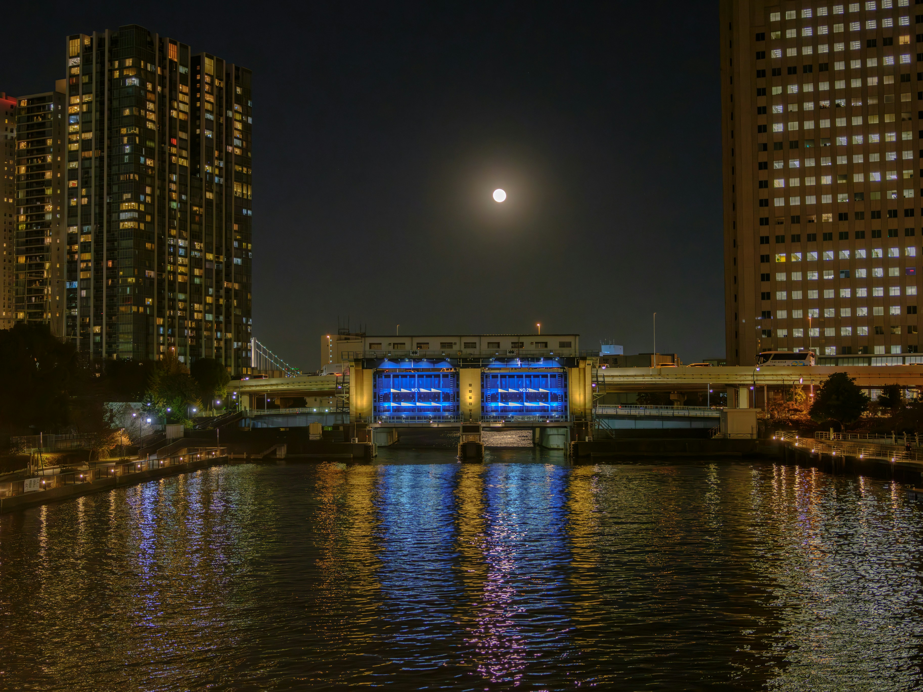 Moonlit Lock and Skyline: Neon-blue Reflections Across the River