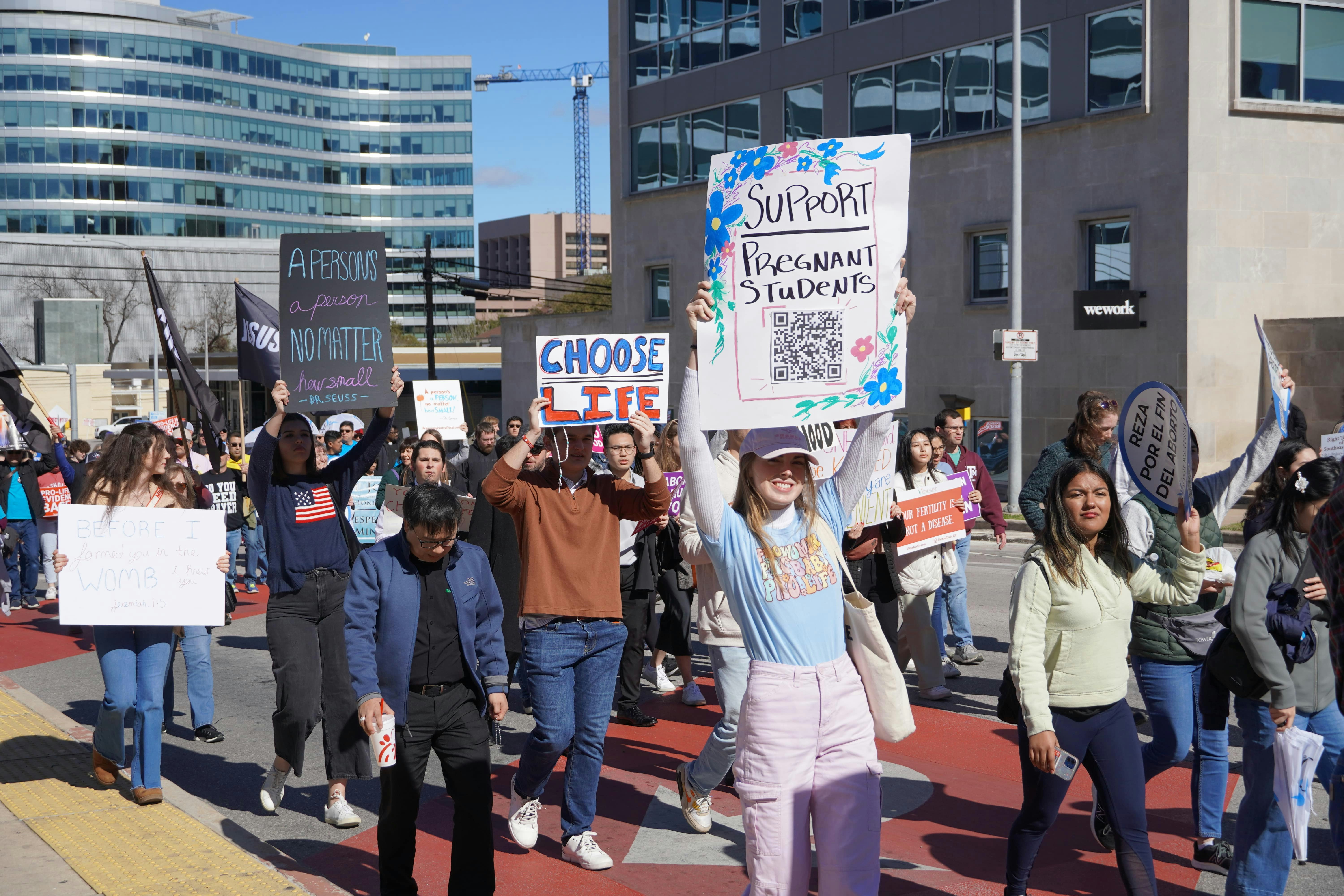 Un grupo de personas marchando por una calle con carteles foto – Imagen ...