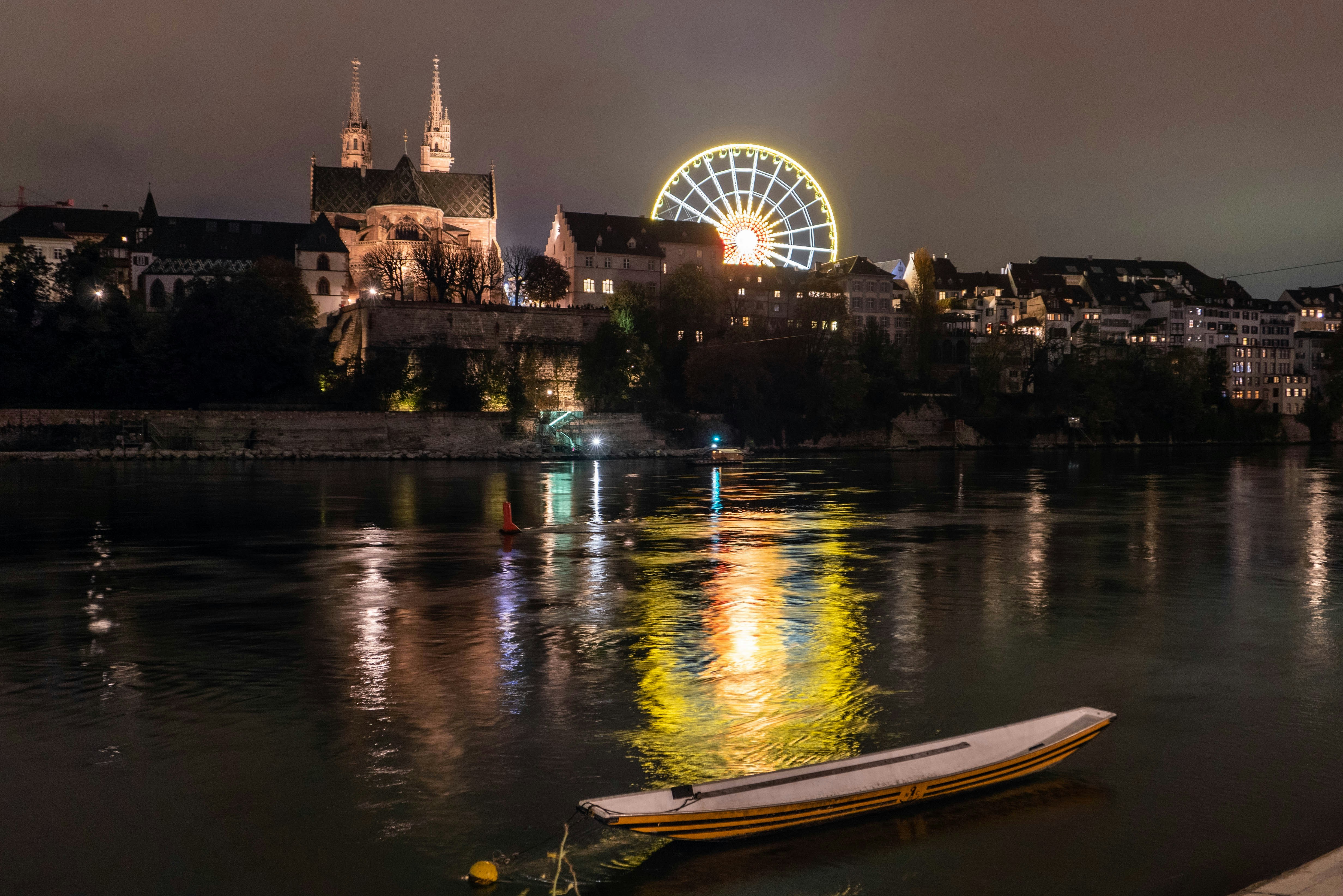 A boat is sitting on the water near a ferris wheel photo – Free Basel ...