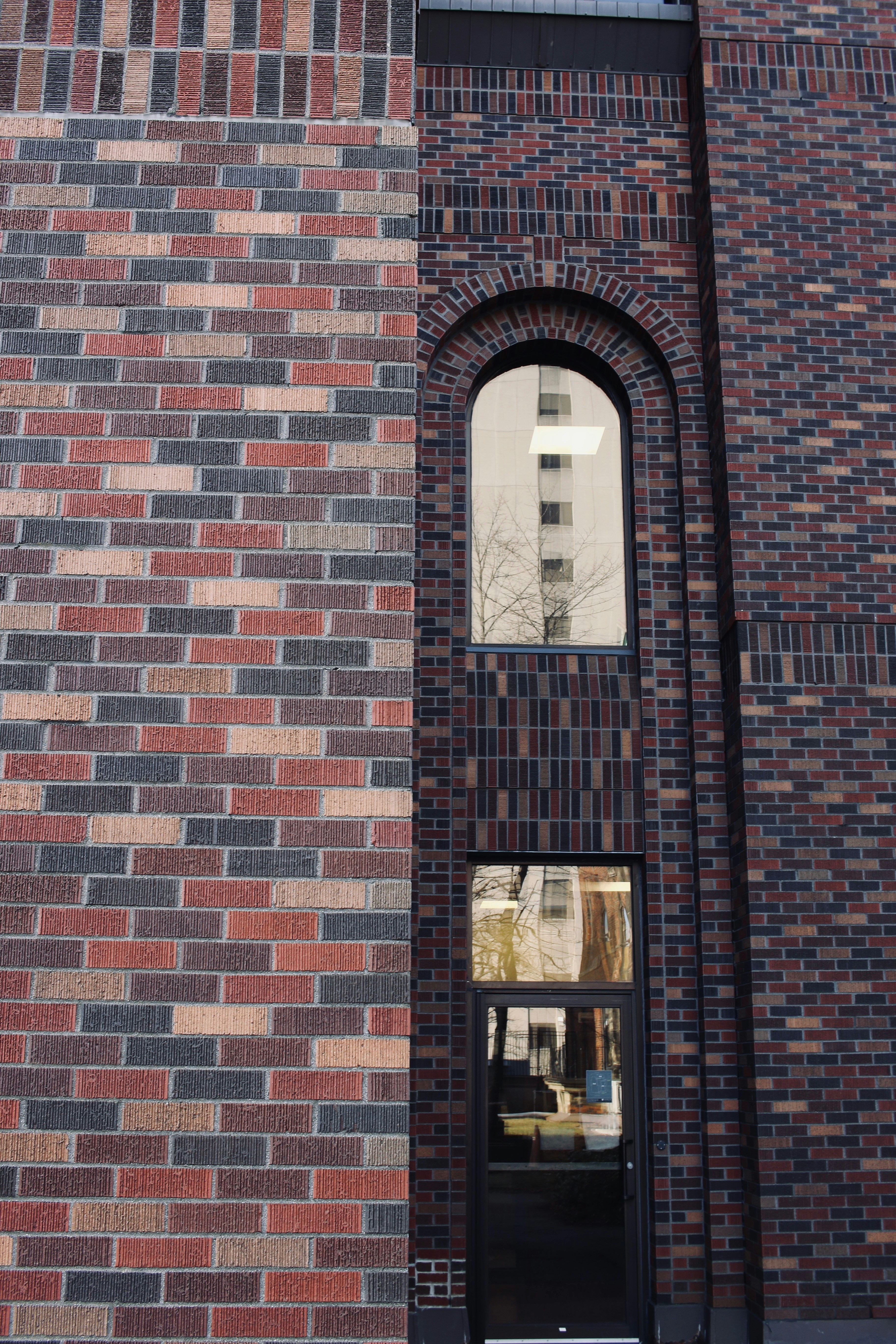 Arched Window Between Brick Facades: A Quiet Vertical Portrait