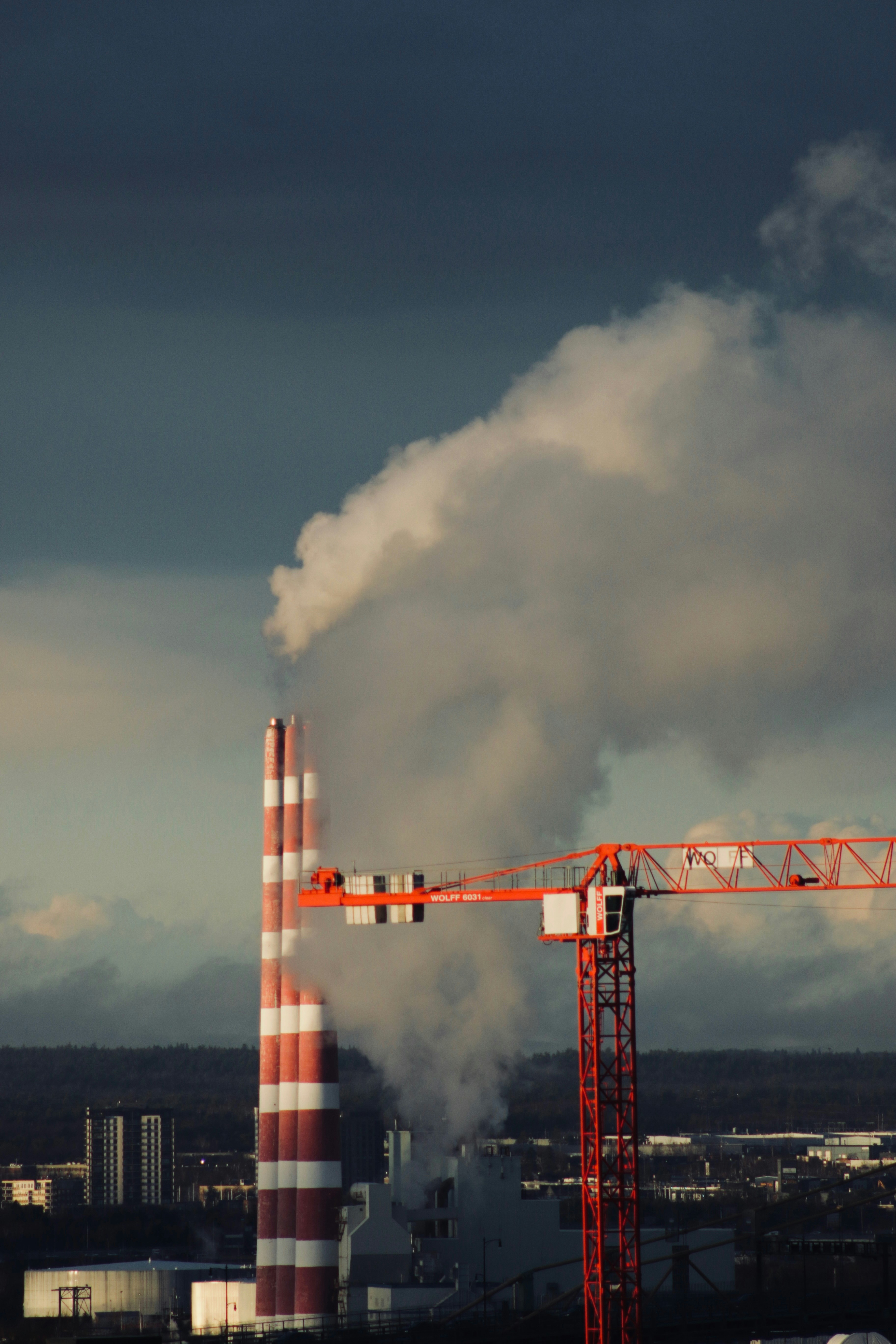 A factory with smoke pouring out of it's stacks photo – Free Smoke ...
