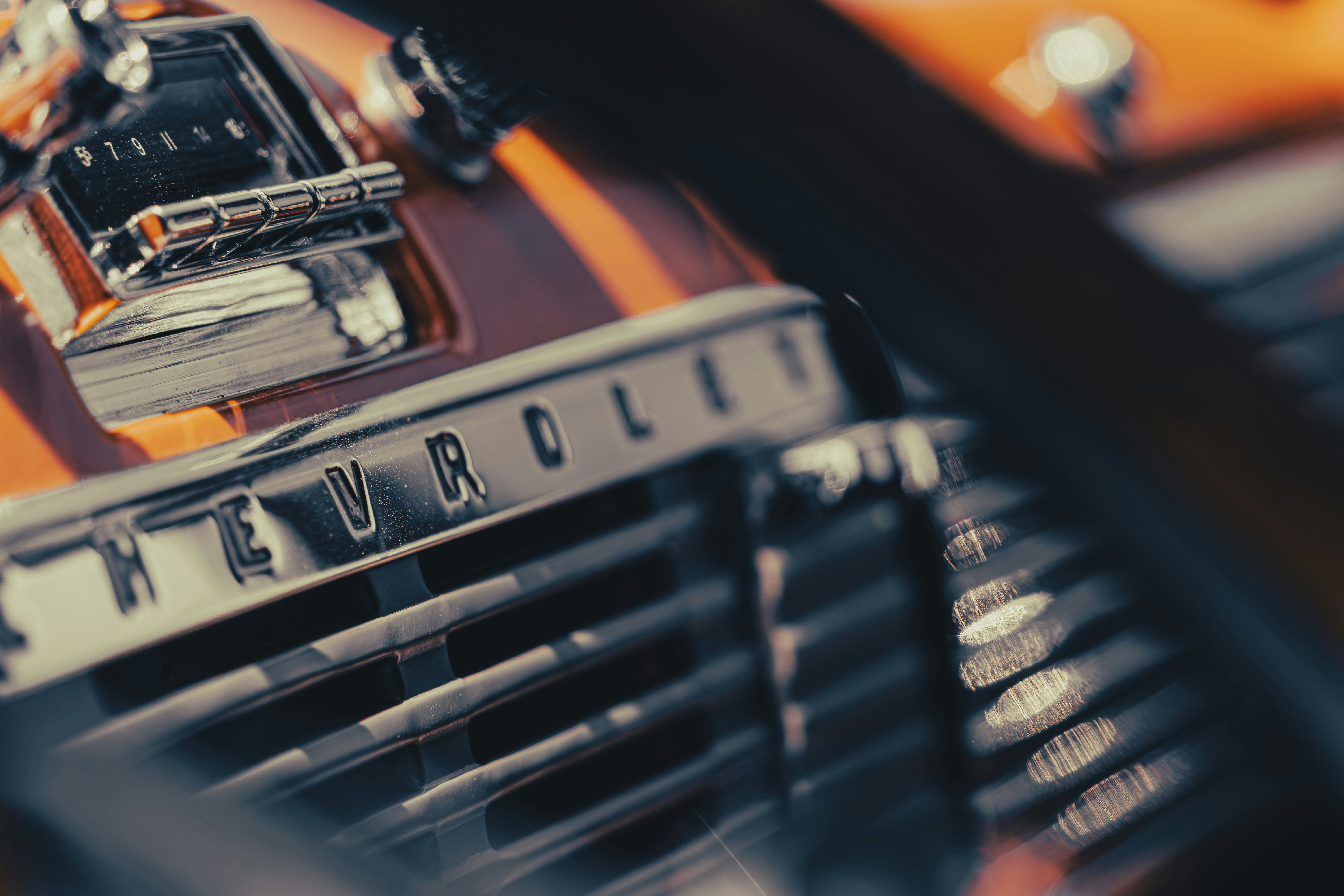 Emblem in Focus: Chrome Chevrolet Crest Framed by Sunset-Orange Grille