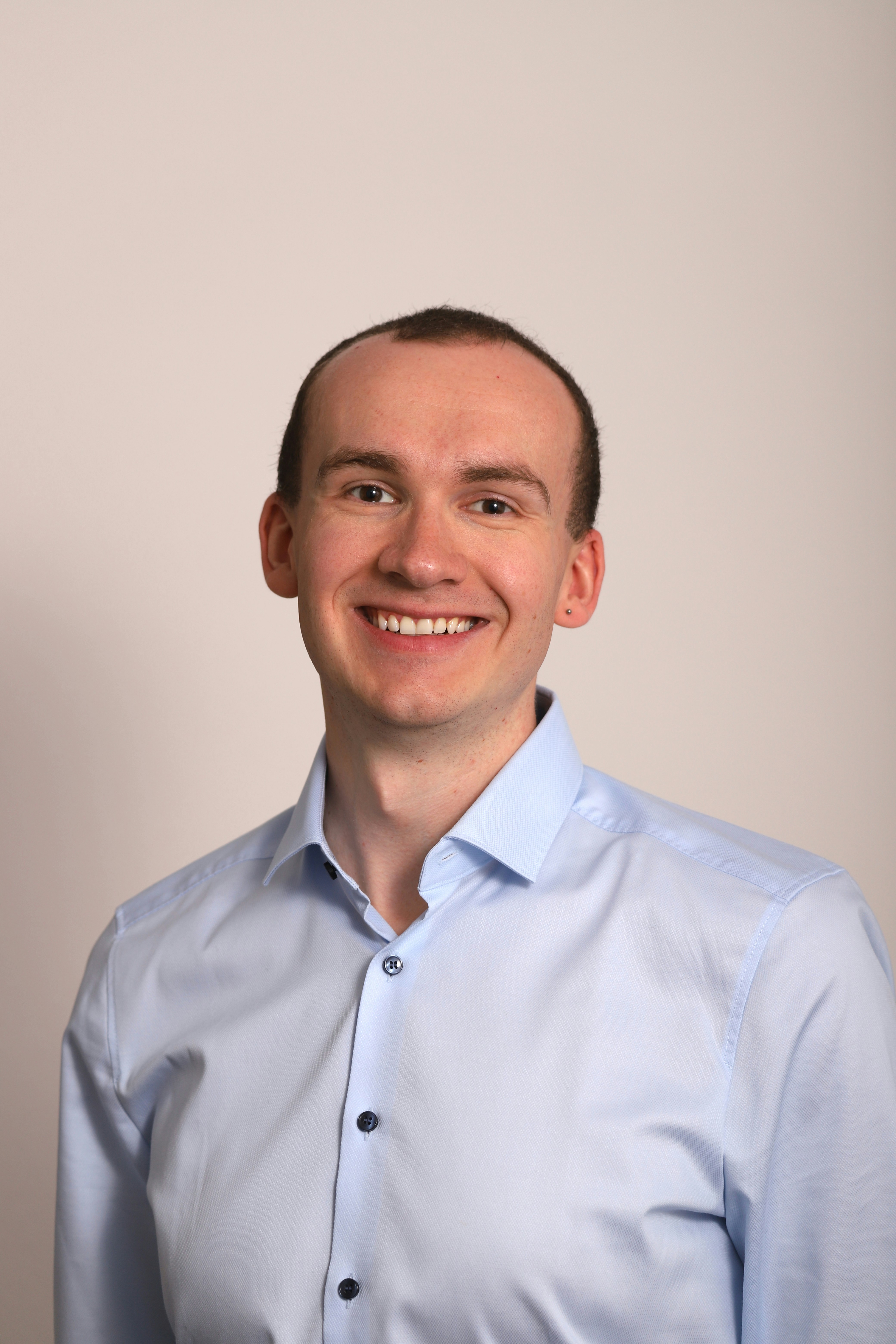 A man in a blue shirt smiling for the camera photo – Free Face Image on ...