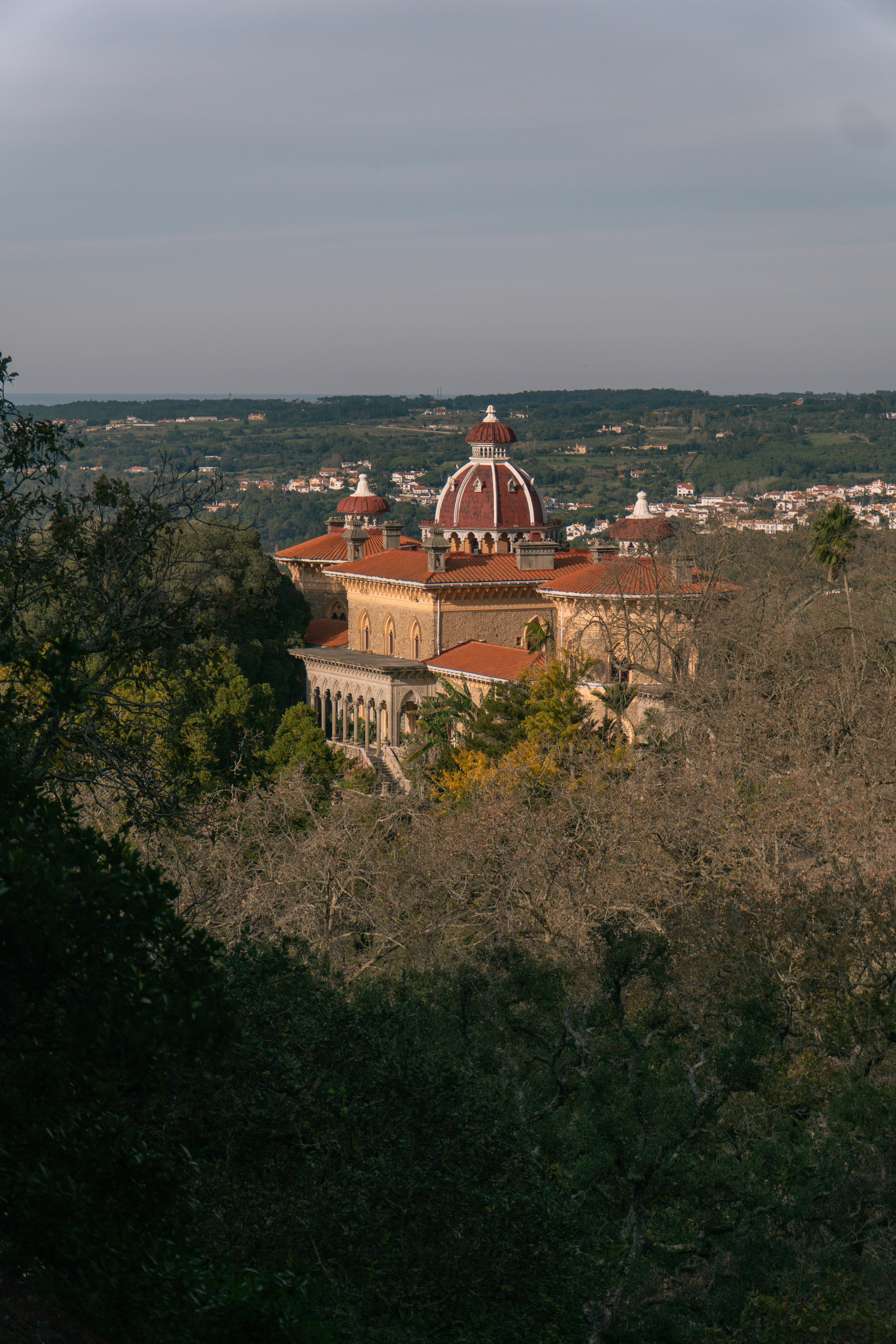 Historic mansion nestled among lush greenery, showcasing intricate architecture against a serene backdrop.