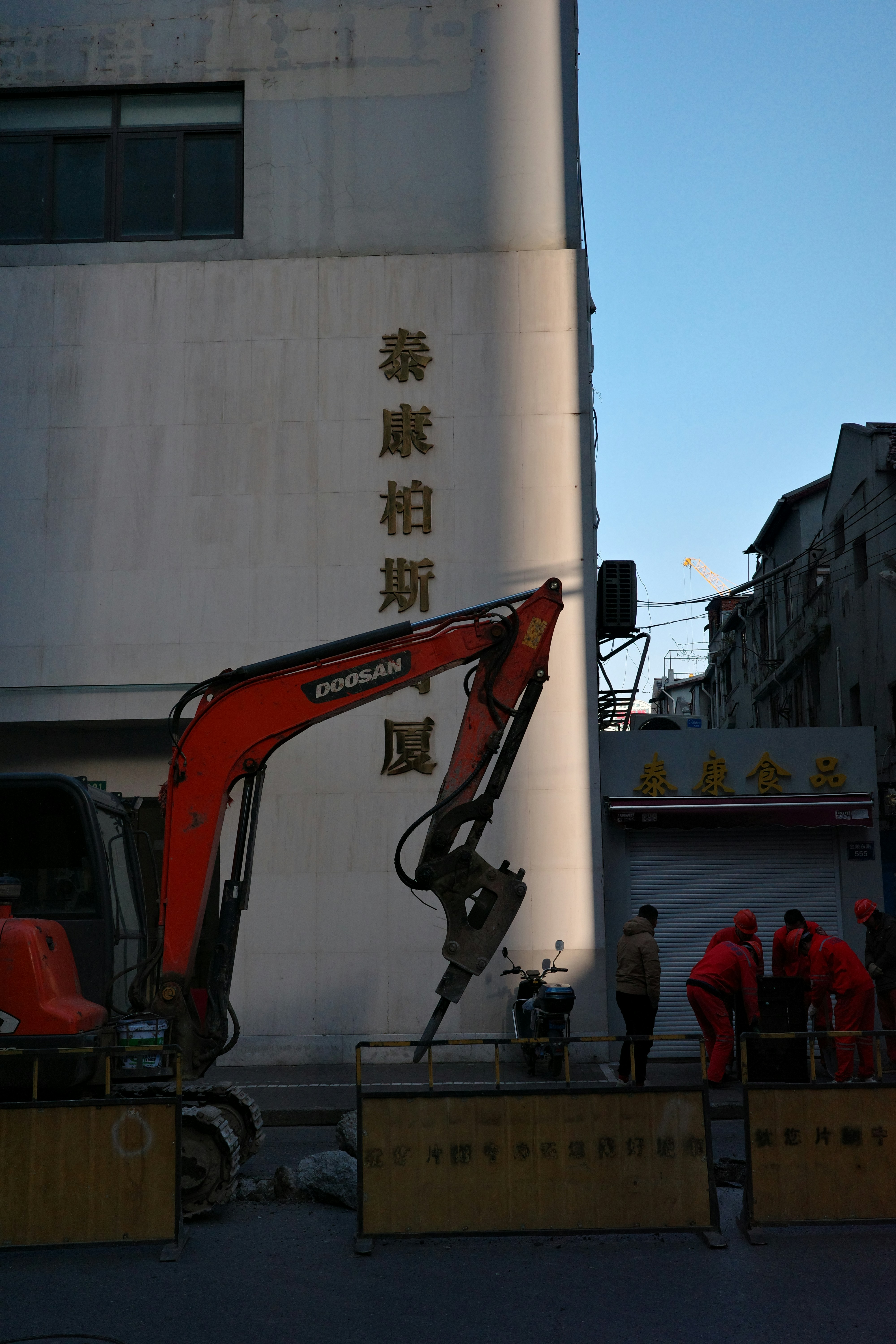 a group of constructor is working next to the excavator