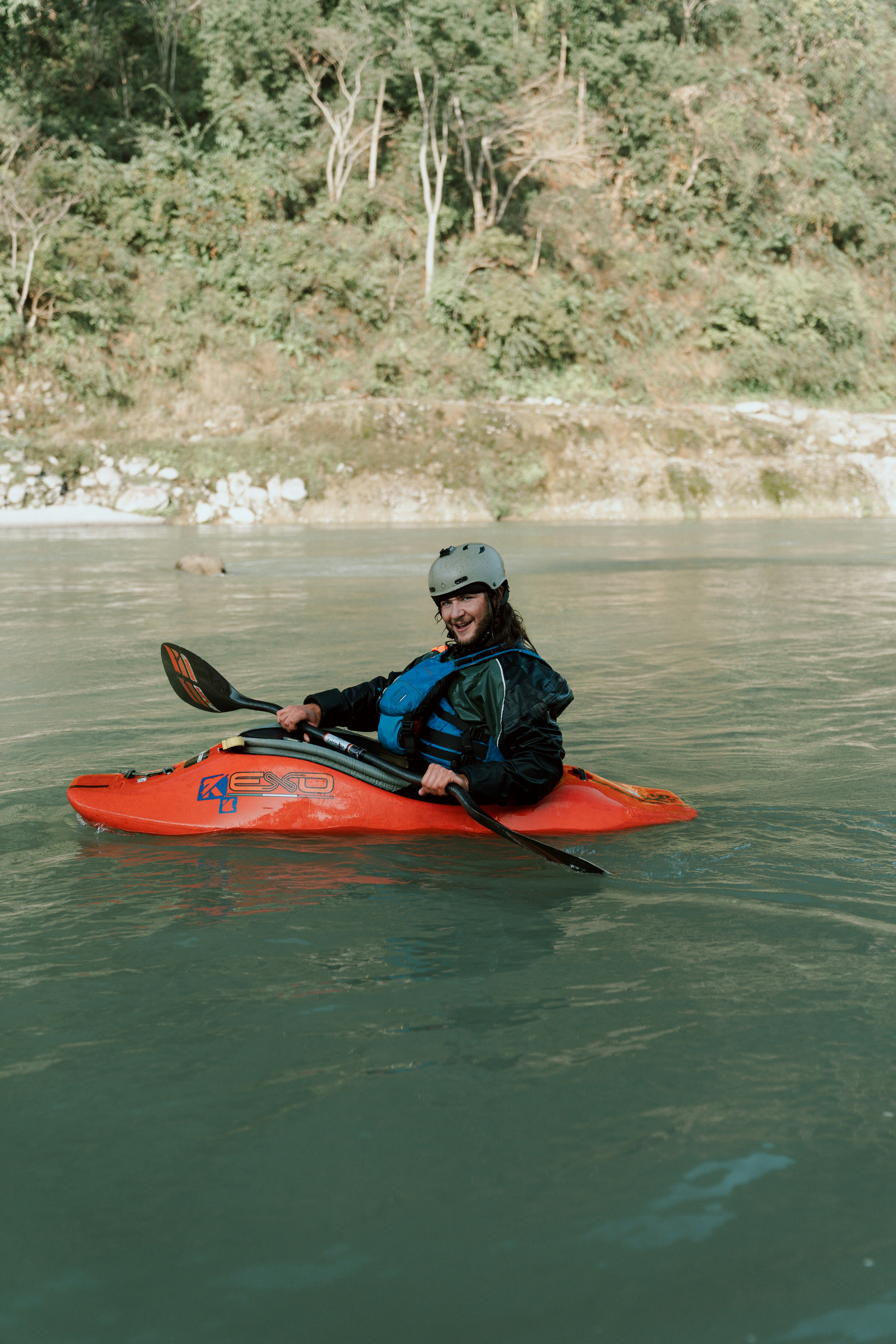 A man riding a kayak on top of a body of water photo – Free Boat Image ...