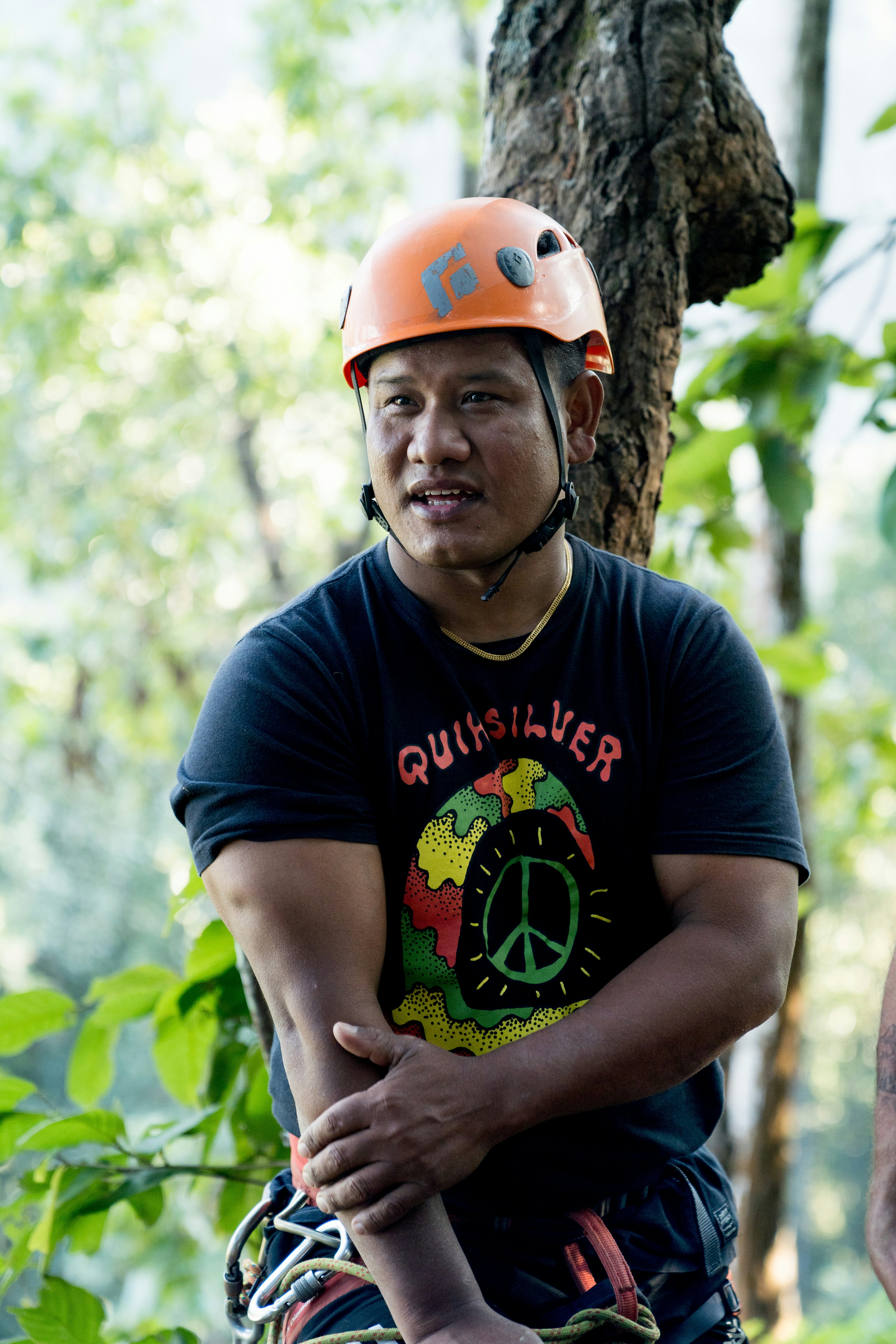 Orange Helmet, Quiet Climb: Portrait of Focus in a Sunlit Forest