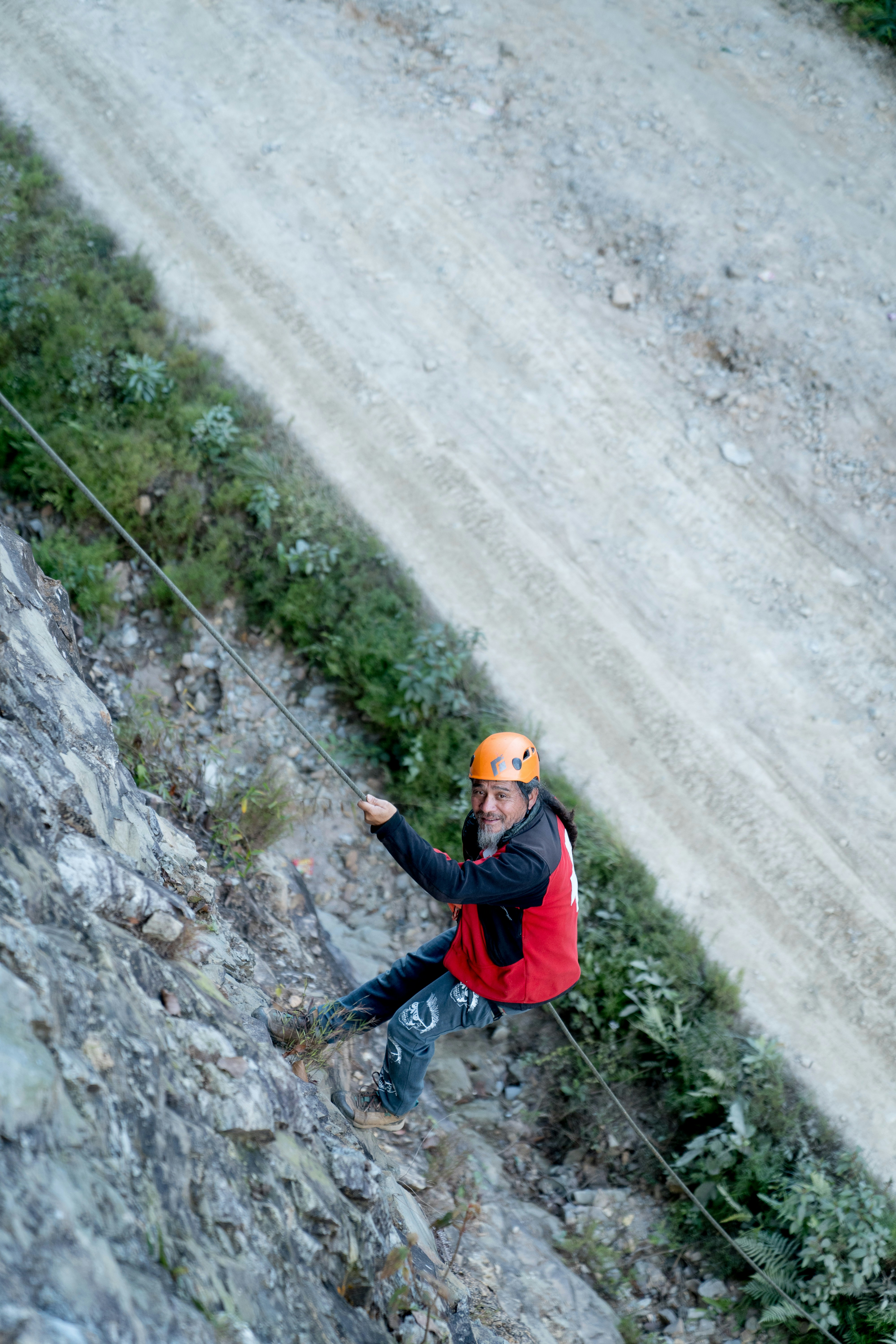 Crux on the Crag: A climber's ascent along a rope-slung ledge