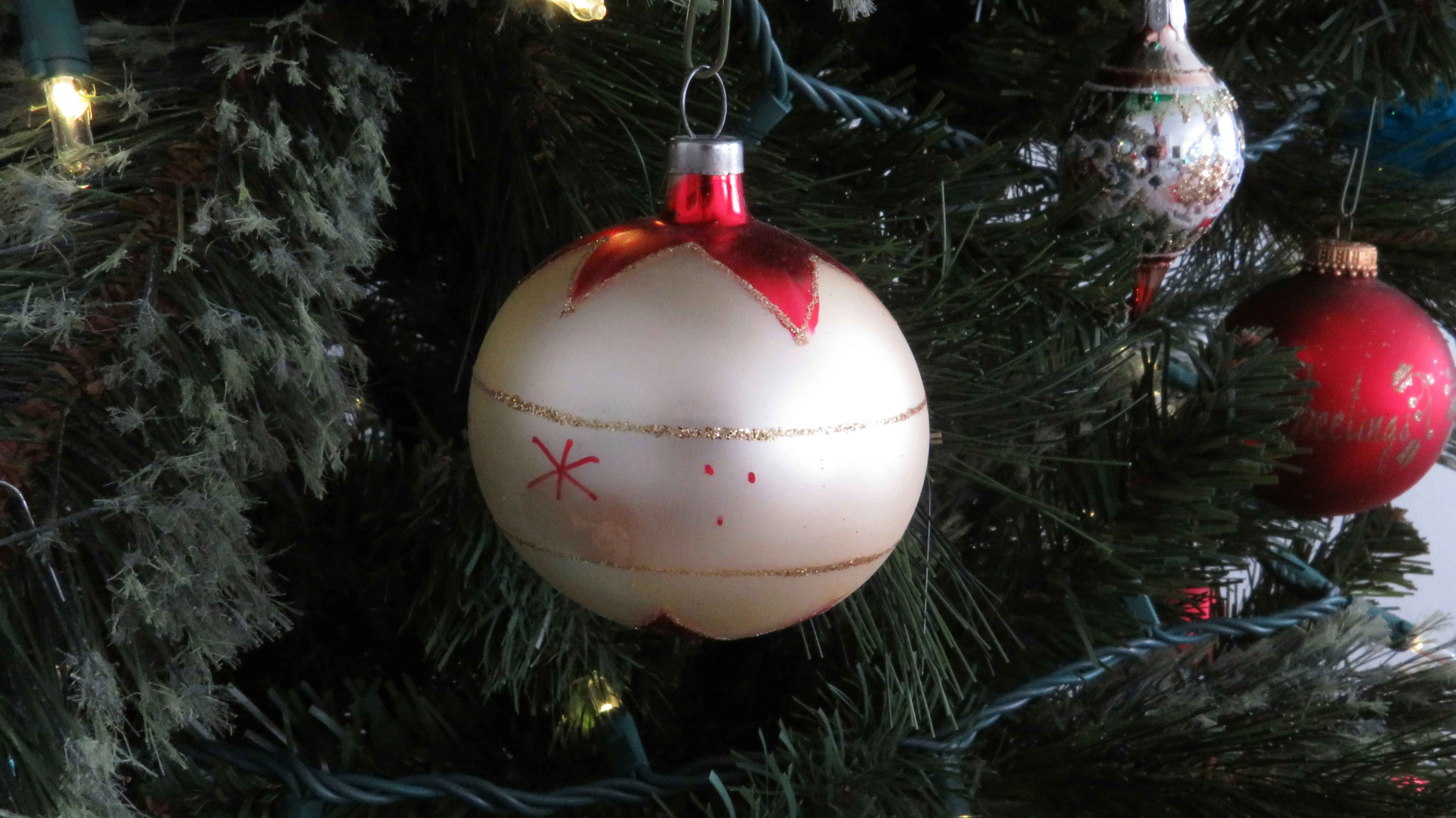 Bauble Glow: a white Christmas ornament punctuating a pine-lit scene