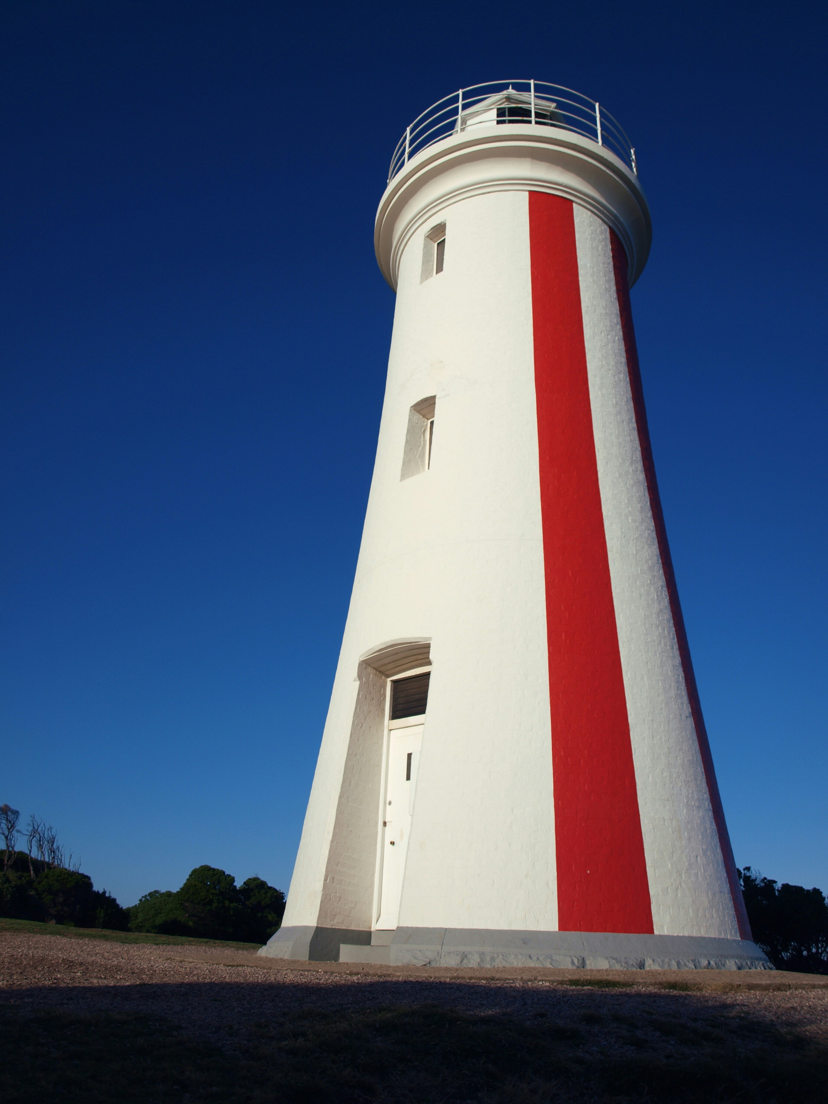 A red and white lighthouse on a clear day photo – Free Lighthouse Image ...