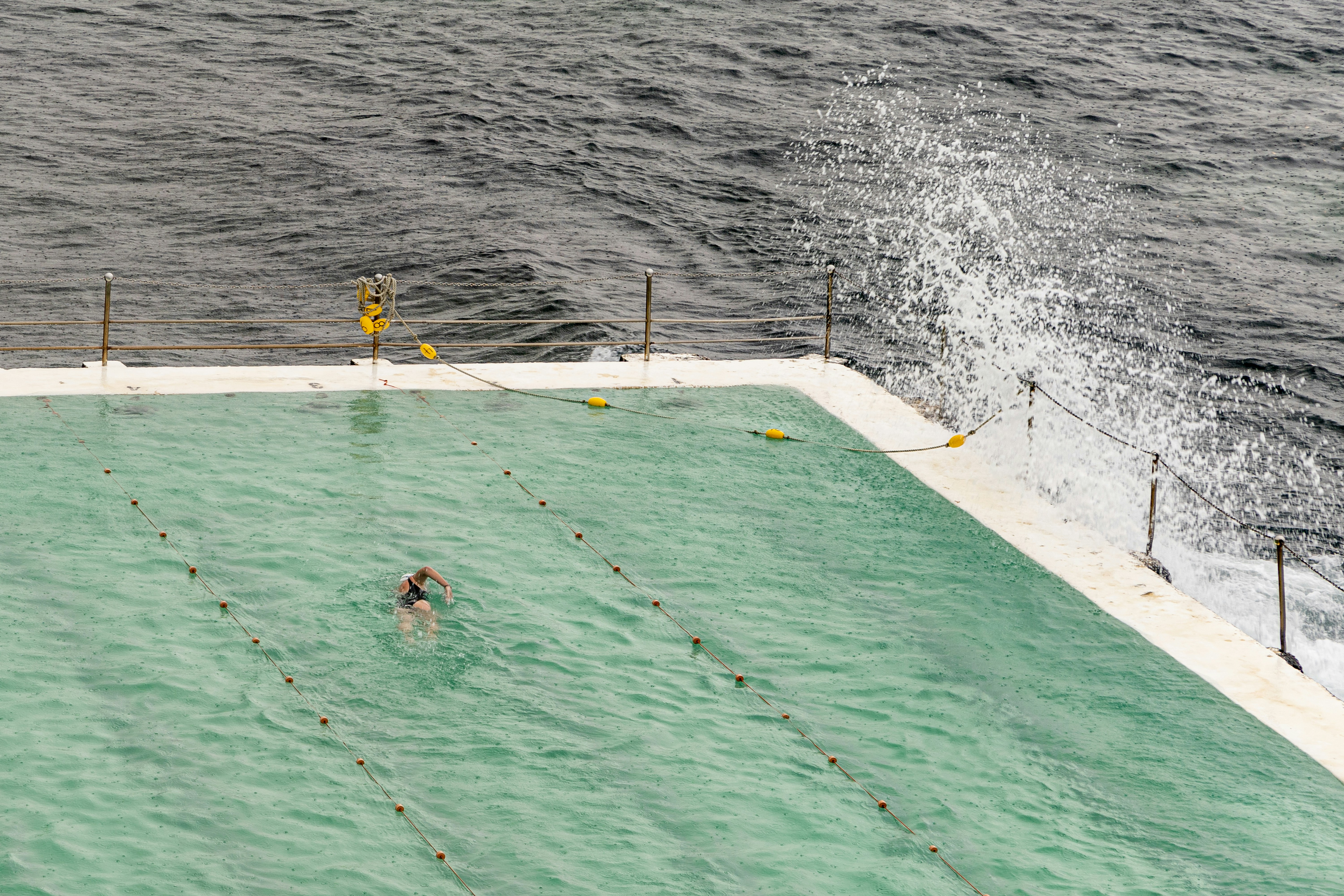 Green-Lit Glide: A Solo Swimmer in a Lane Pool