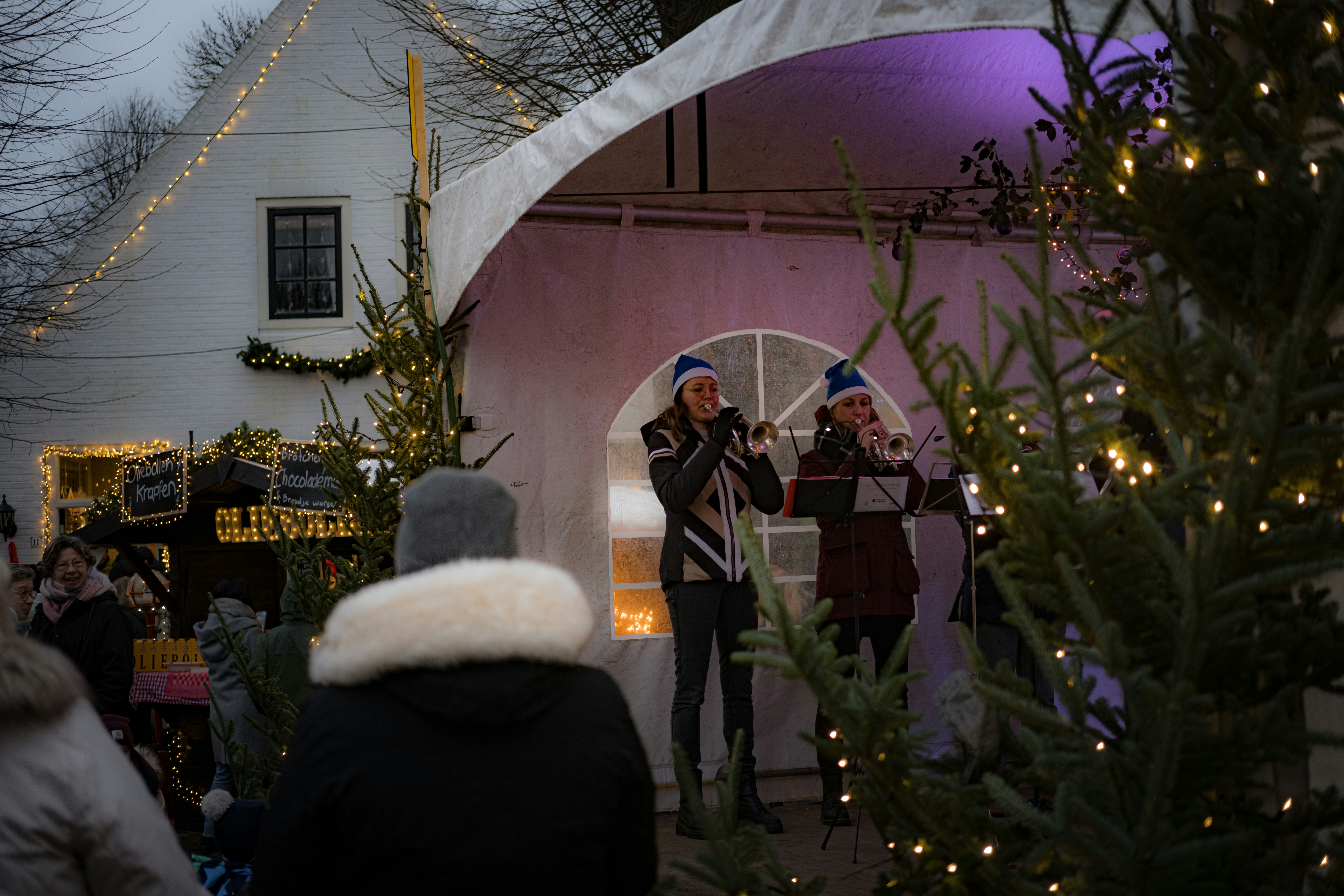 A group of people standing around a christmas tree photo – Free ...