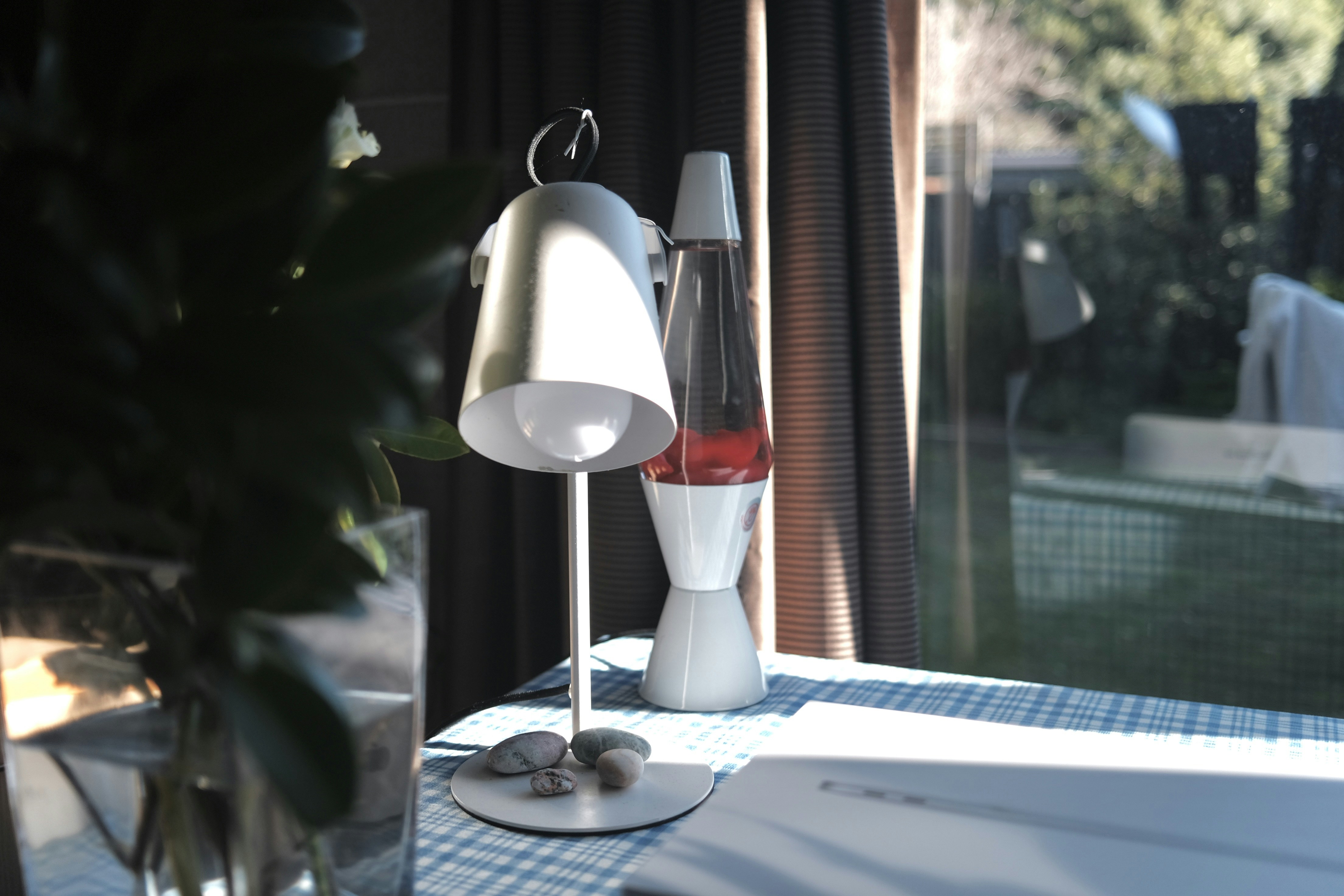 Solar Quietude: White Desk Lamp Meets Lava Lamp in Sunlit Tabletop