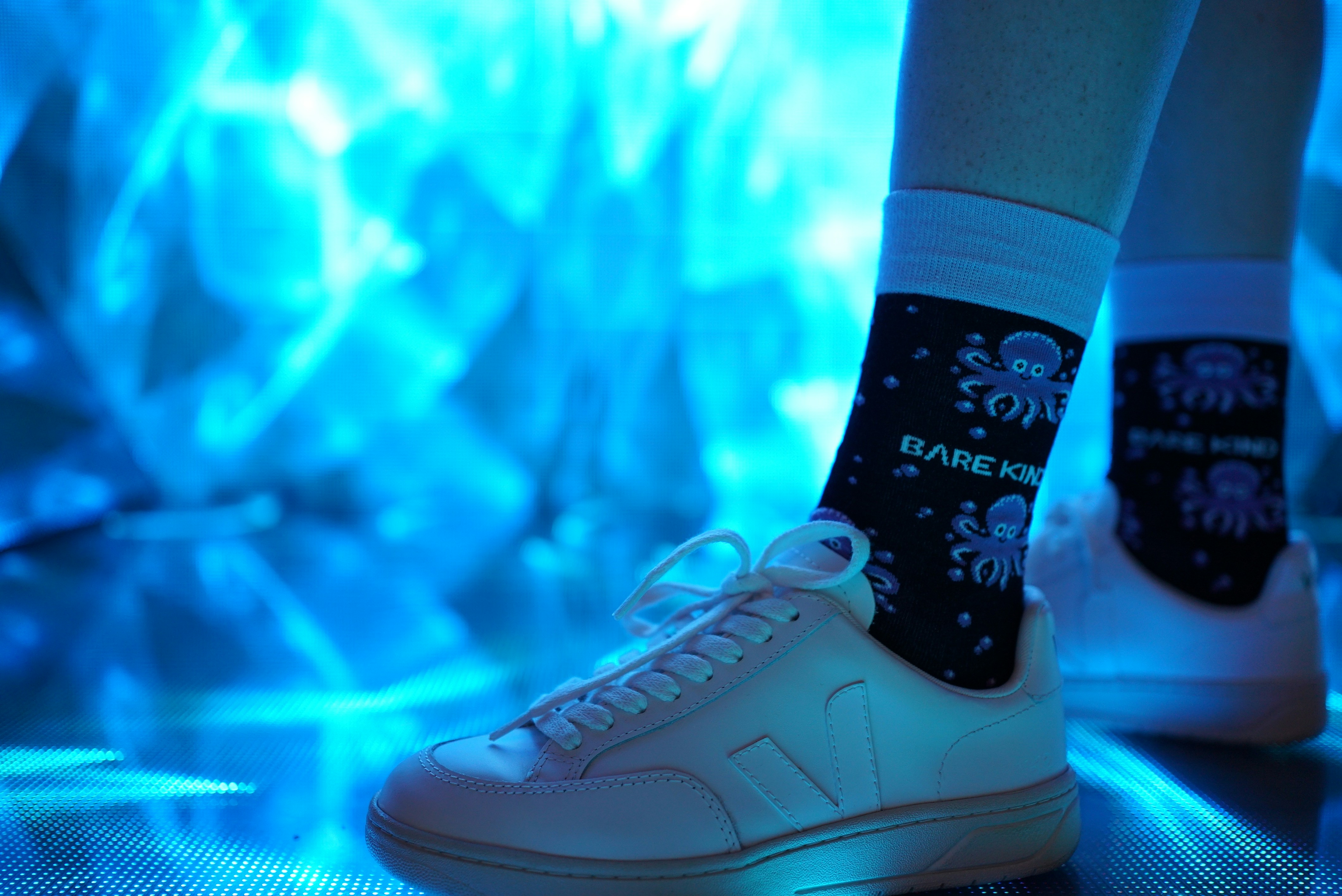 Sole Under Neon: White Sneaker in a Blue Glow